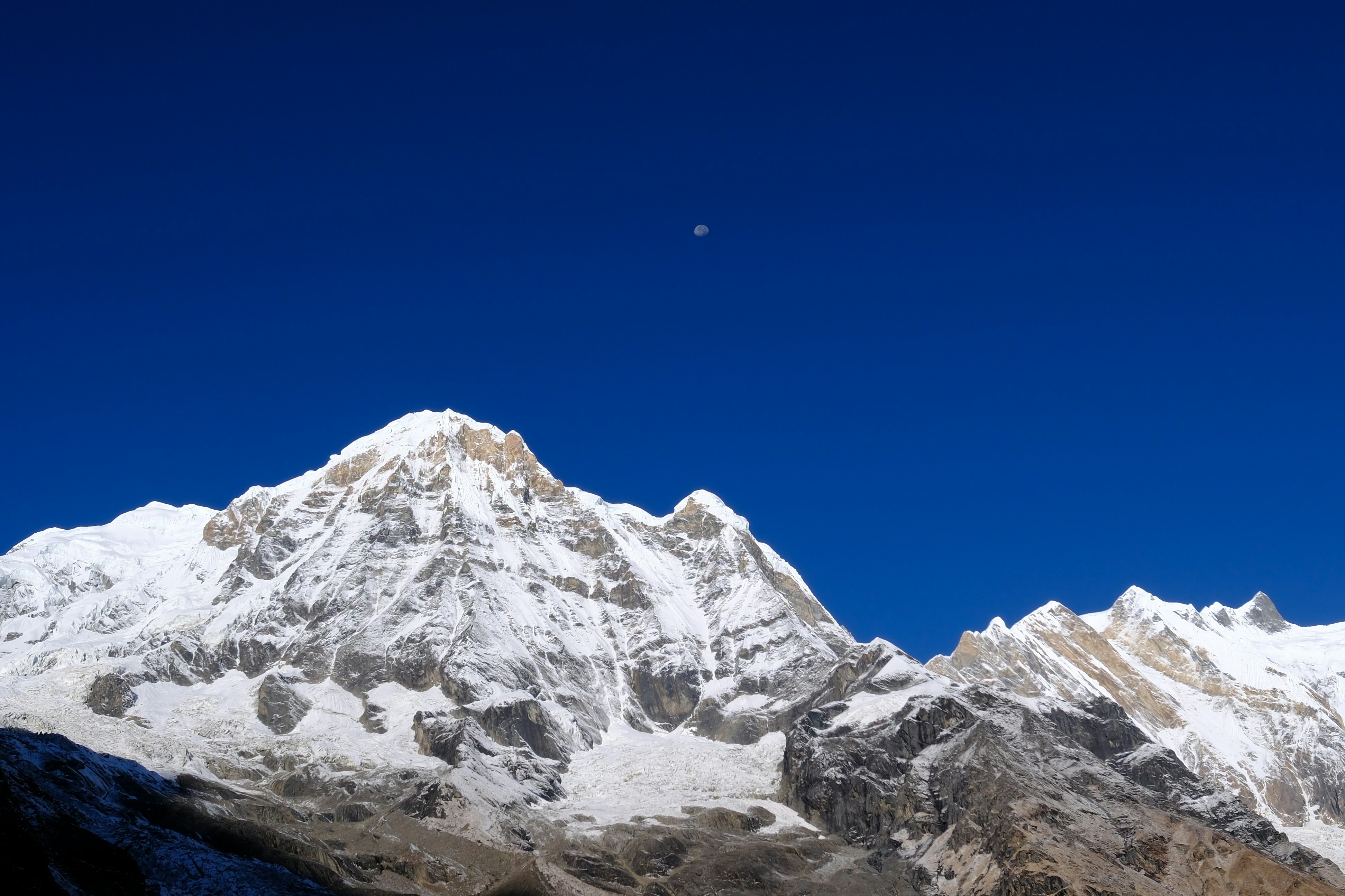 A snow covered mountain with a moon in the sky photo – Free Snow Image ...