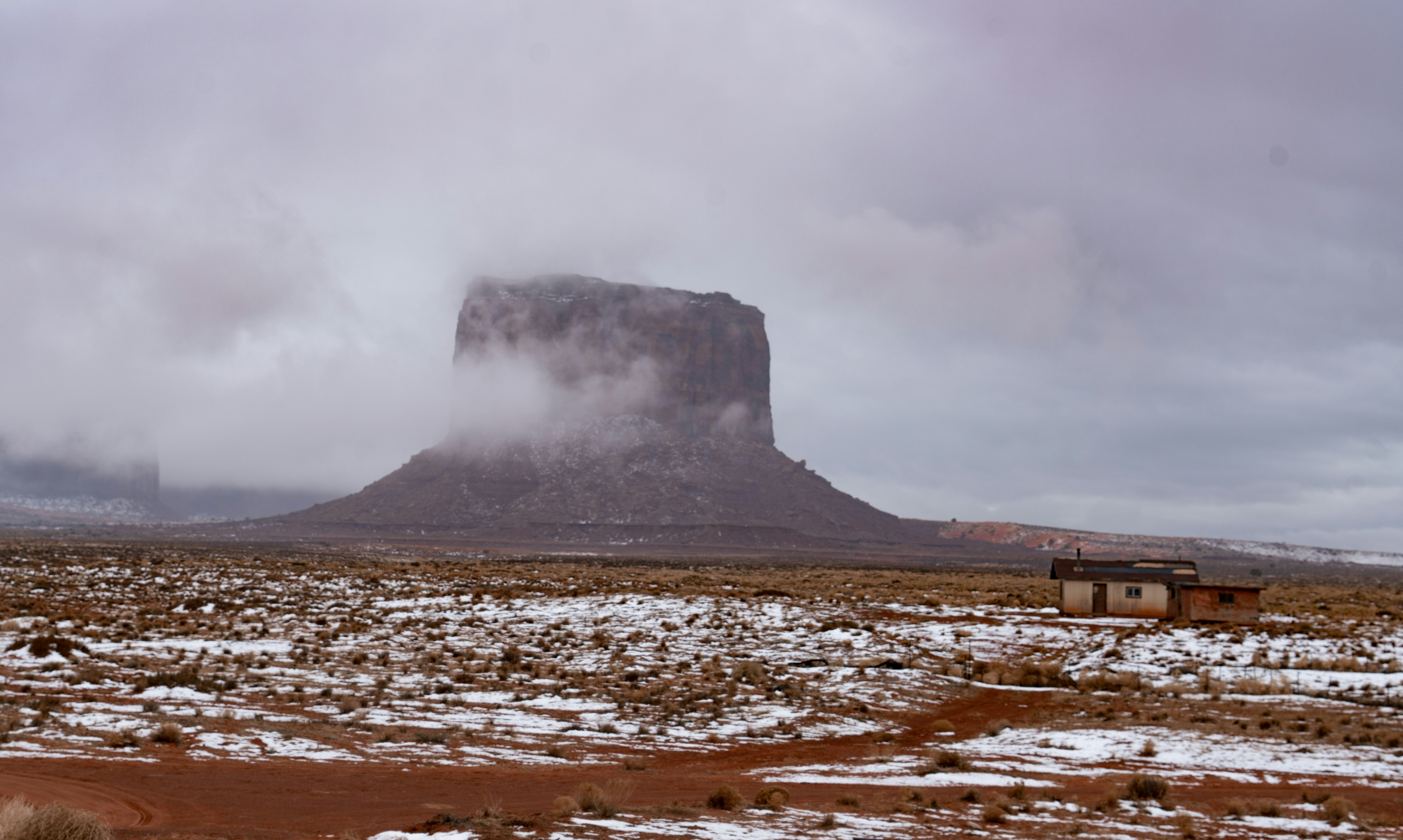 Snow-Kissed Mesa Under a Drifting Gray Sky