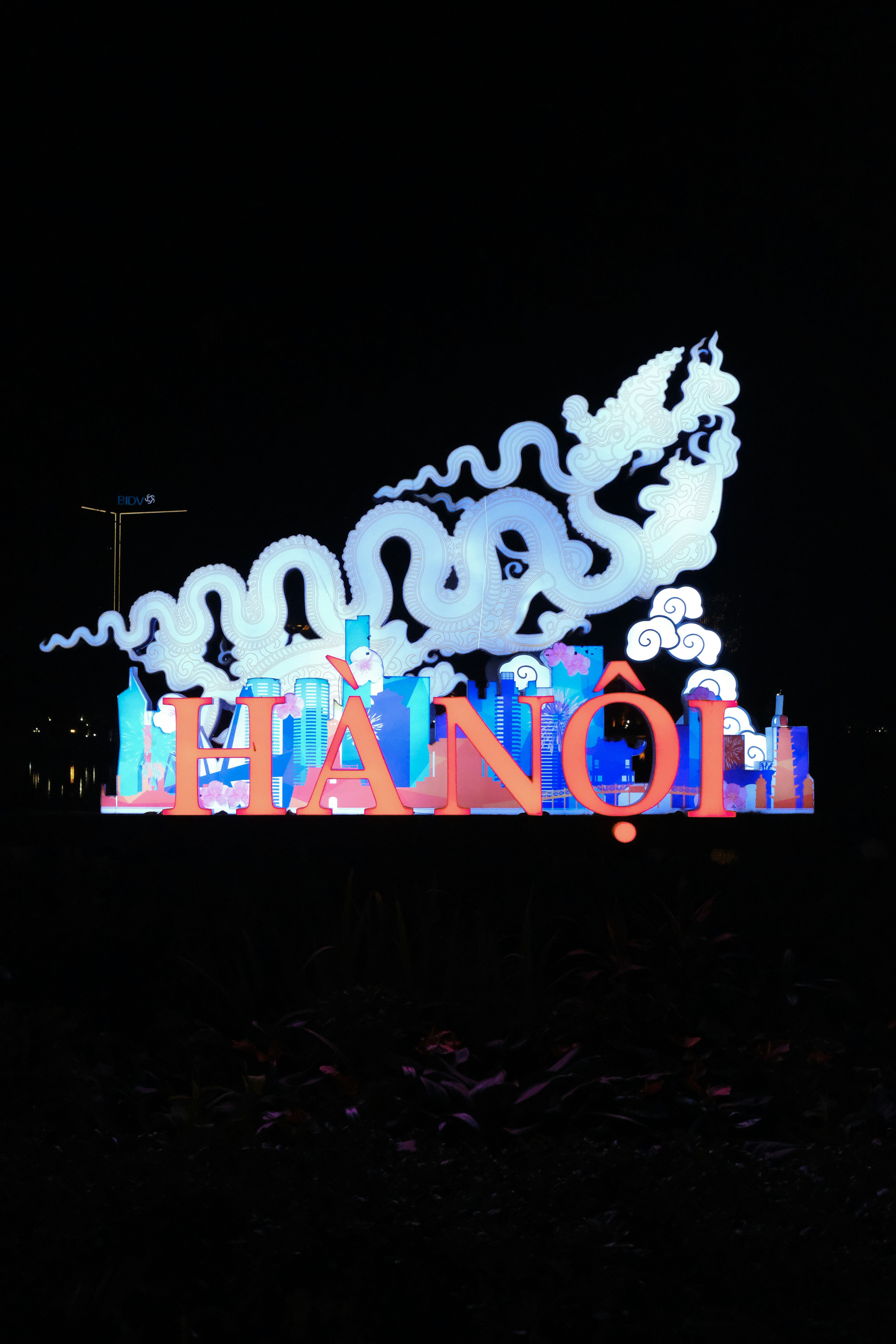 Hanoi Neon Dragon Over a Multicolored Cityscape Sign