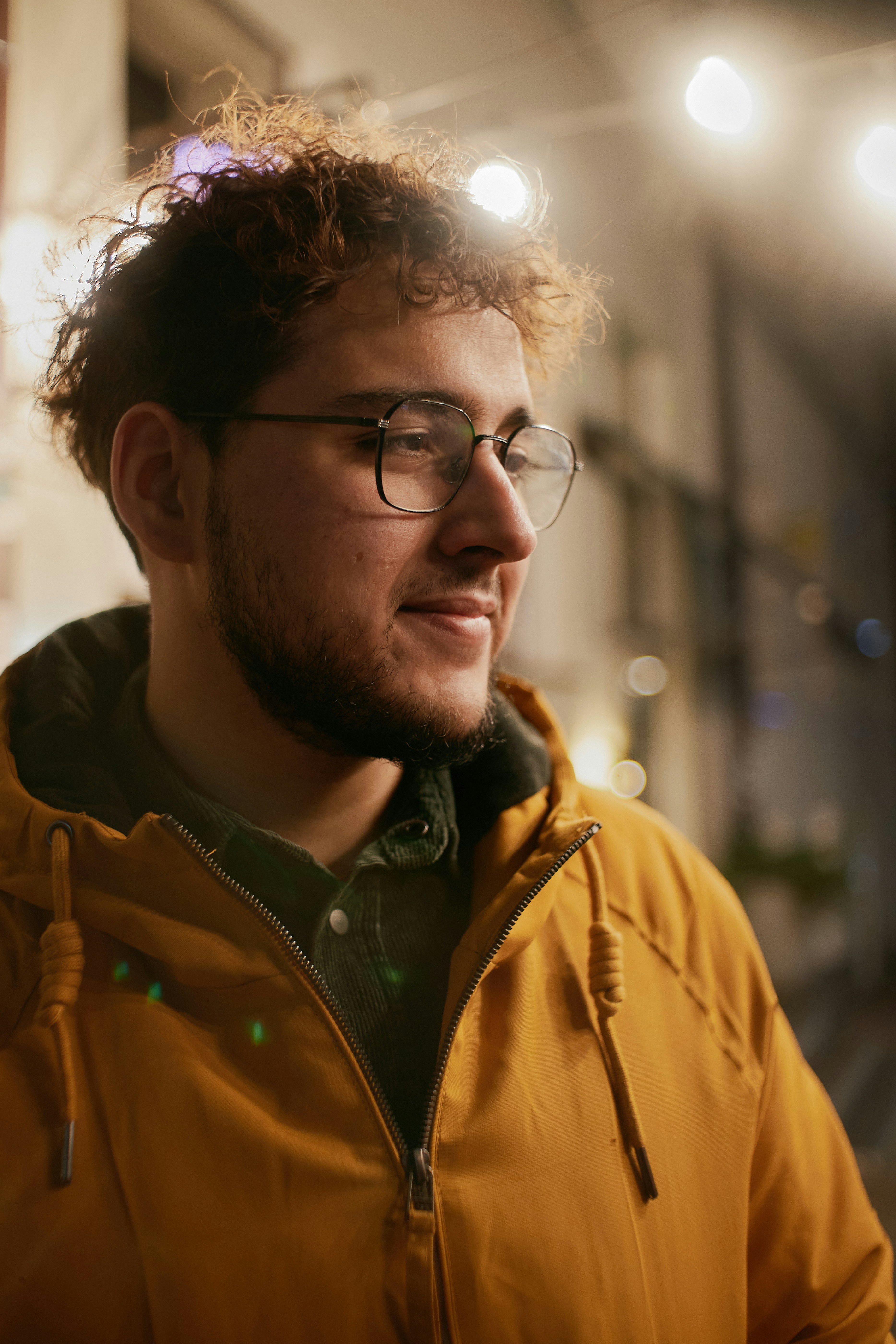 Amber Streetlight Portrait: A Contemplative Moment in a Winter Coat