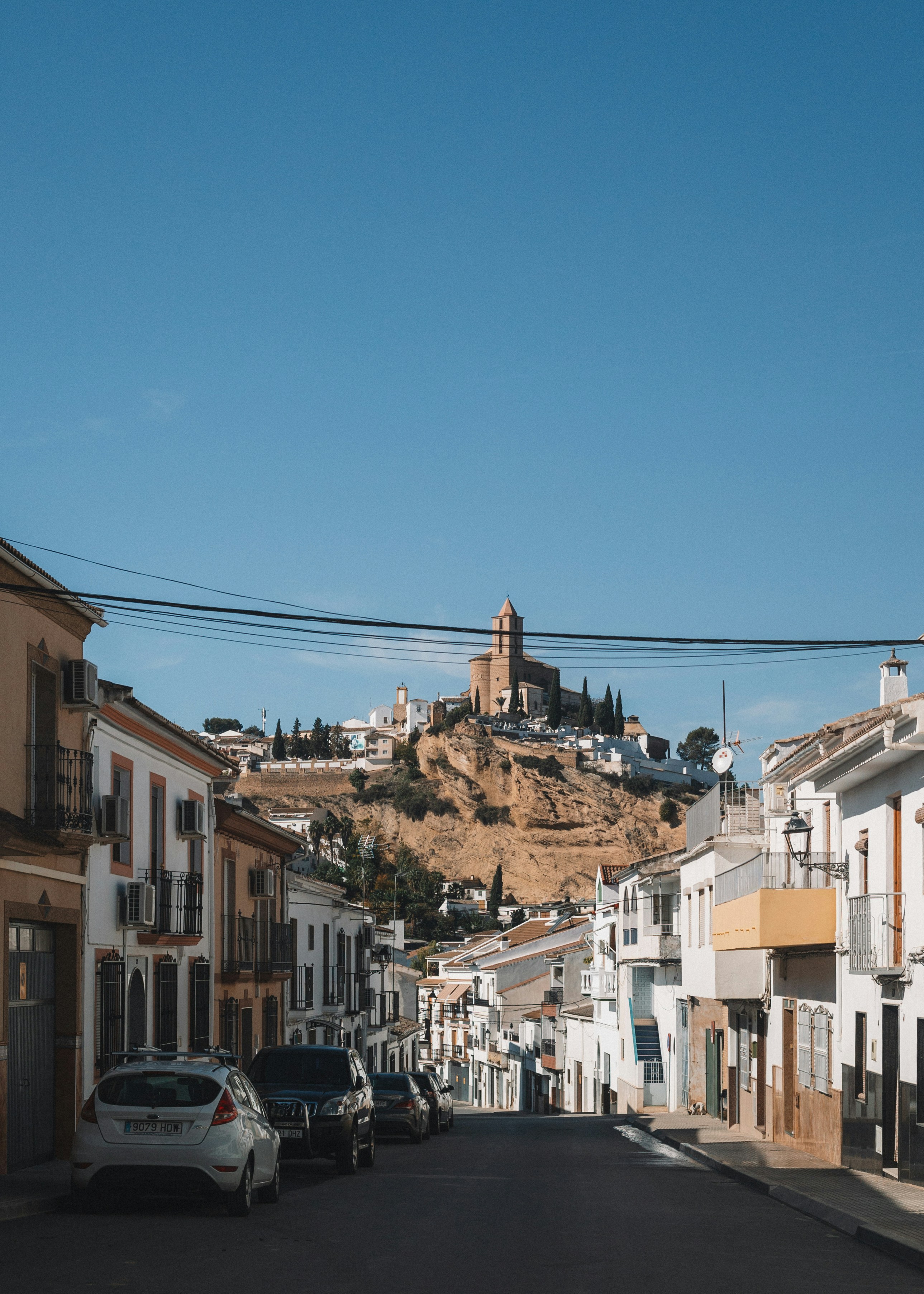 Clifftop Fortress Beyond a Sunlit Calle