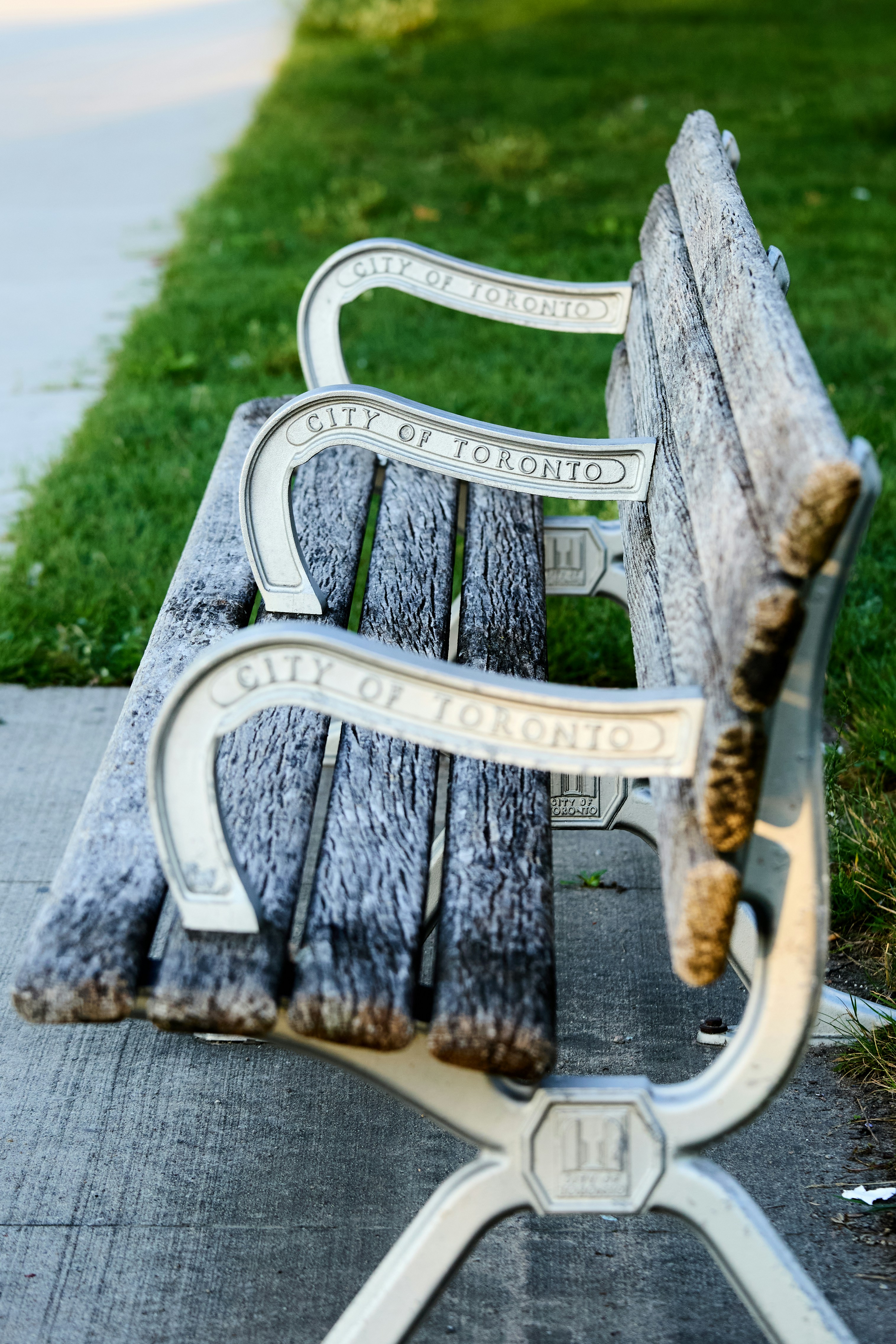 A park bench sitting on the side of a road photo – Free Park Image on ...