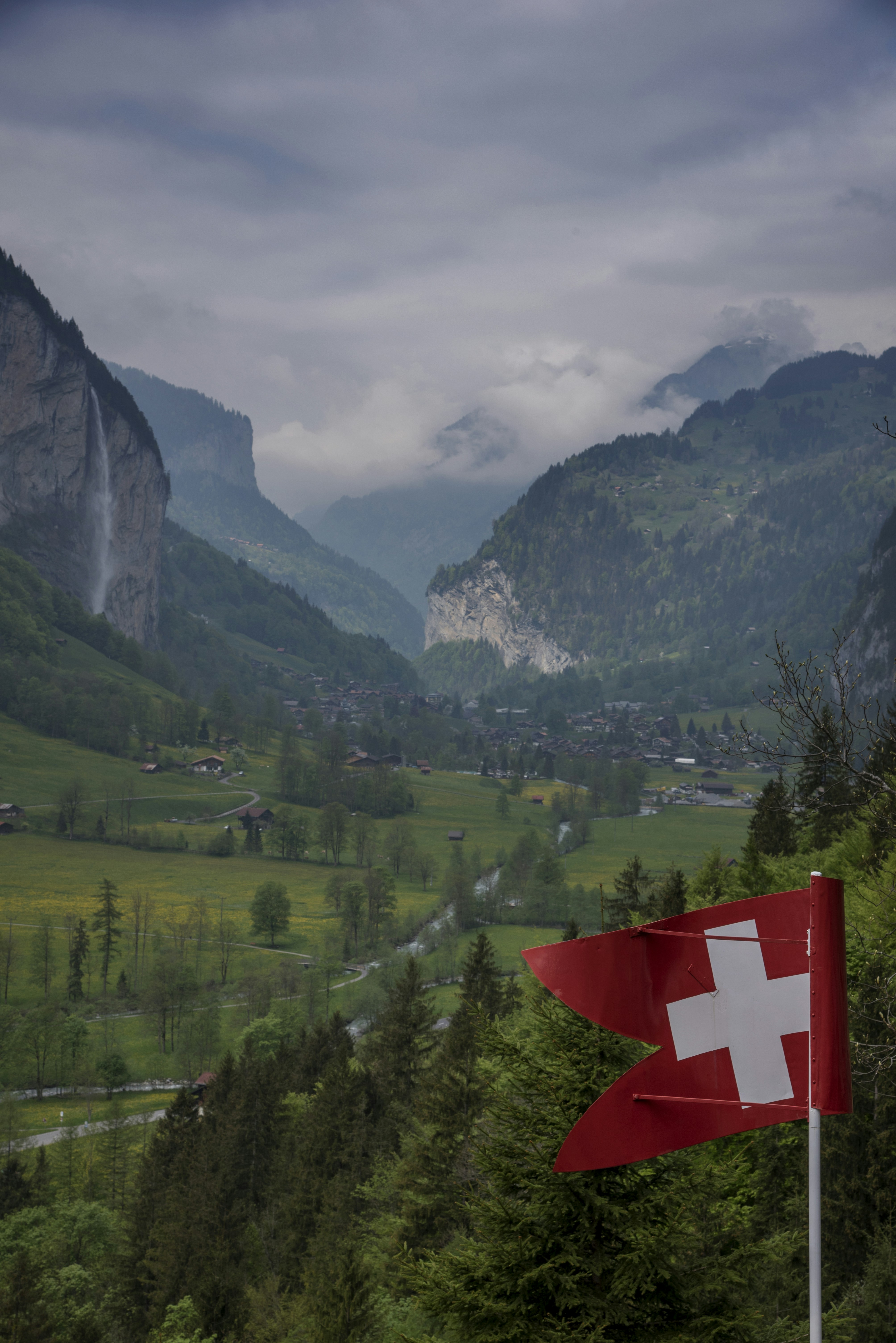 A swiss flag flying in front of mountains photo – Free Green Image on ...