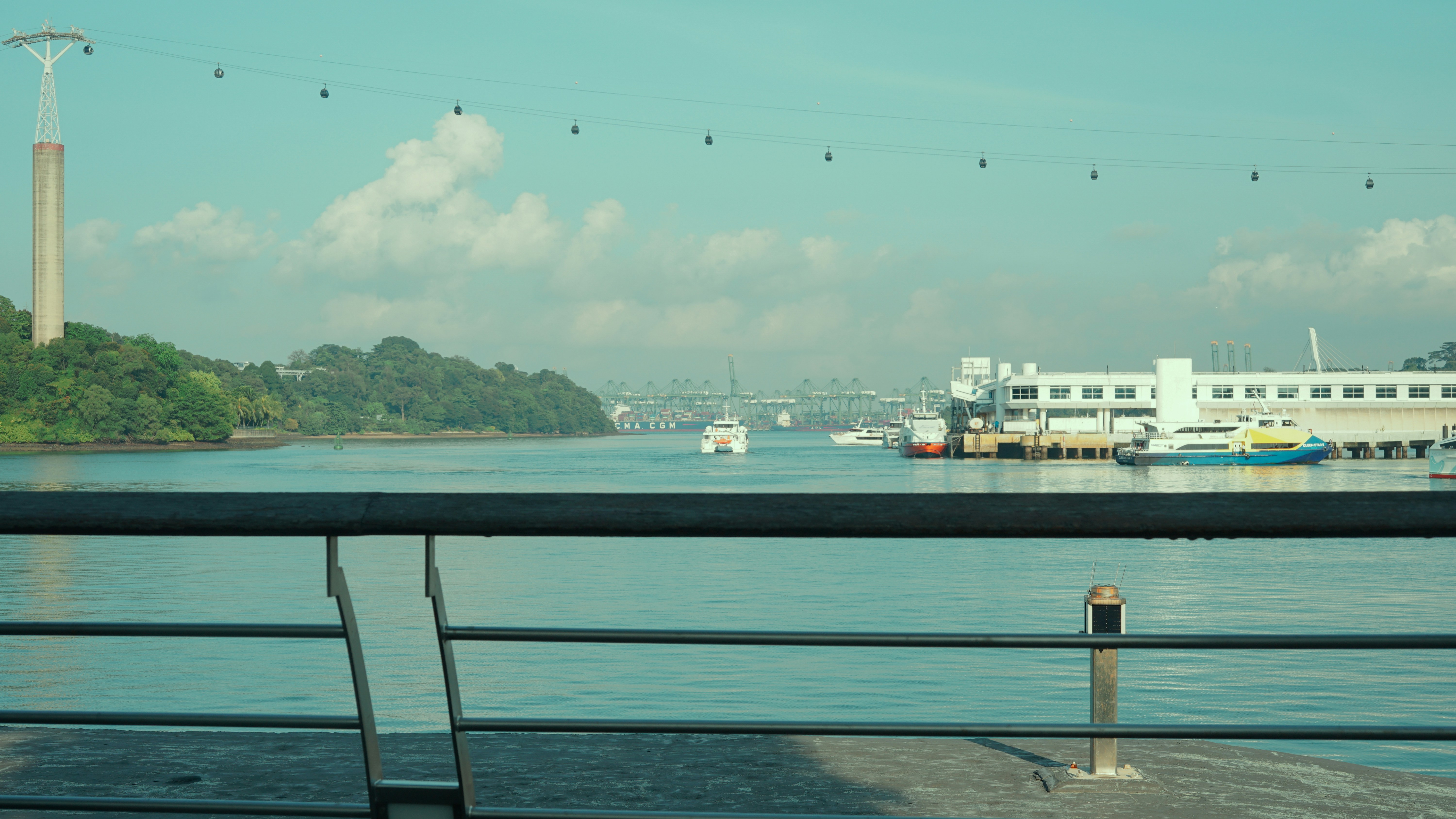Harbor Railscape: Distant Boats under a Teal Sky