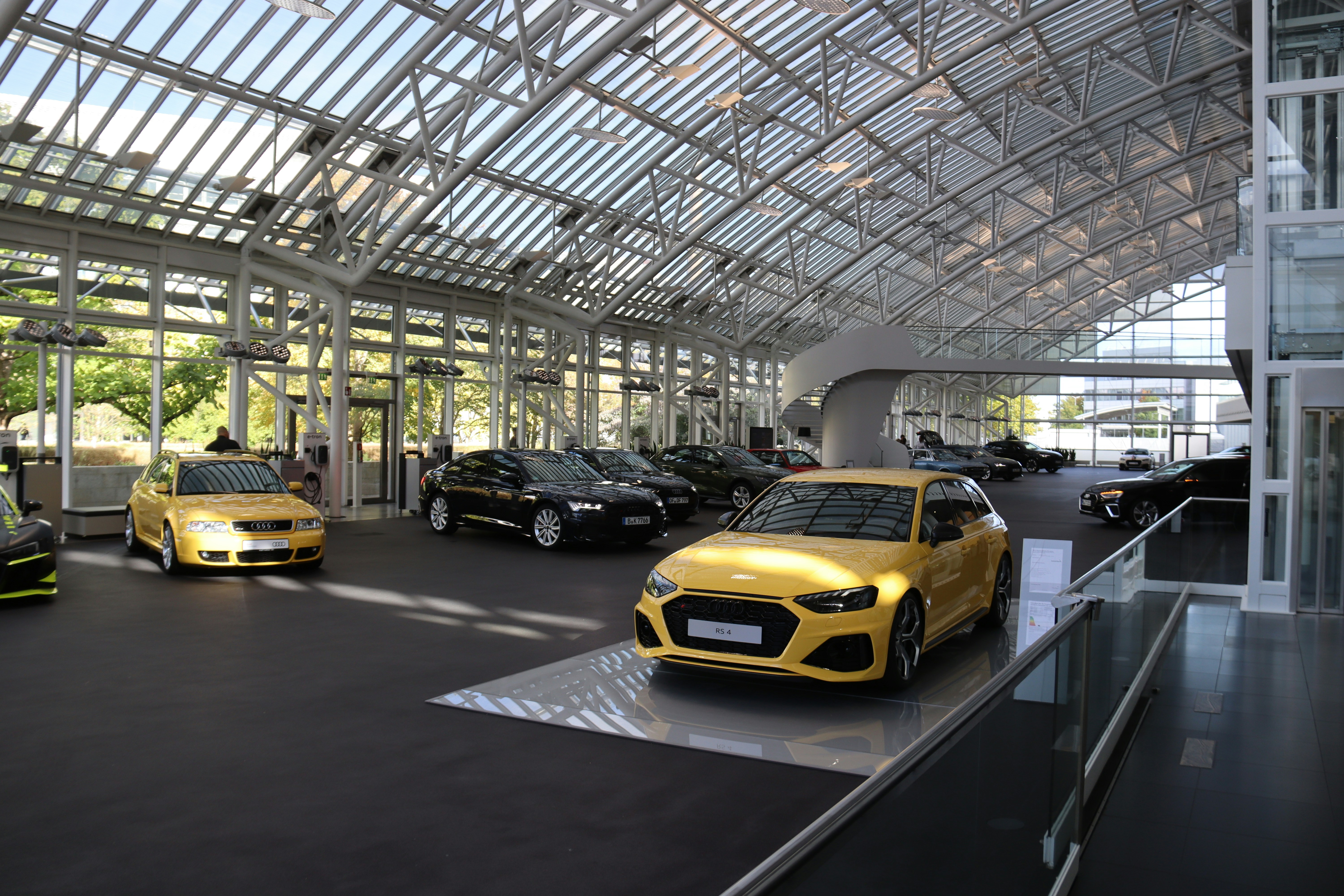 Sunlit Yellow Sedan Anchors a Modern Glasshouse Showroom
