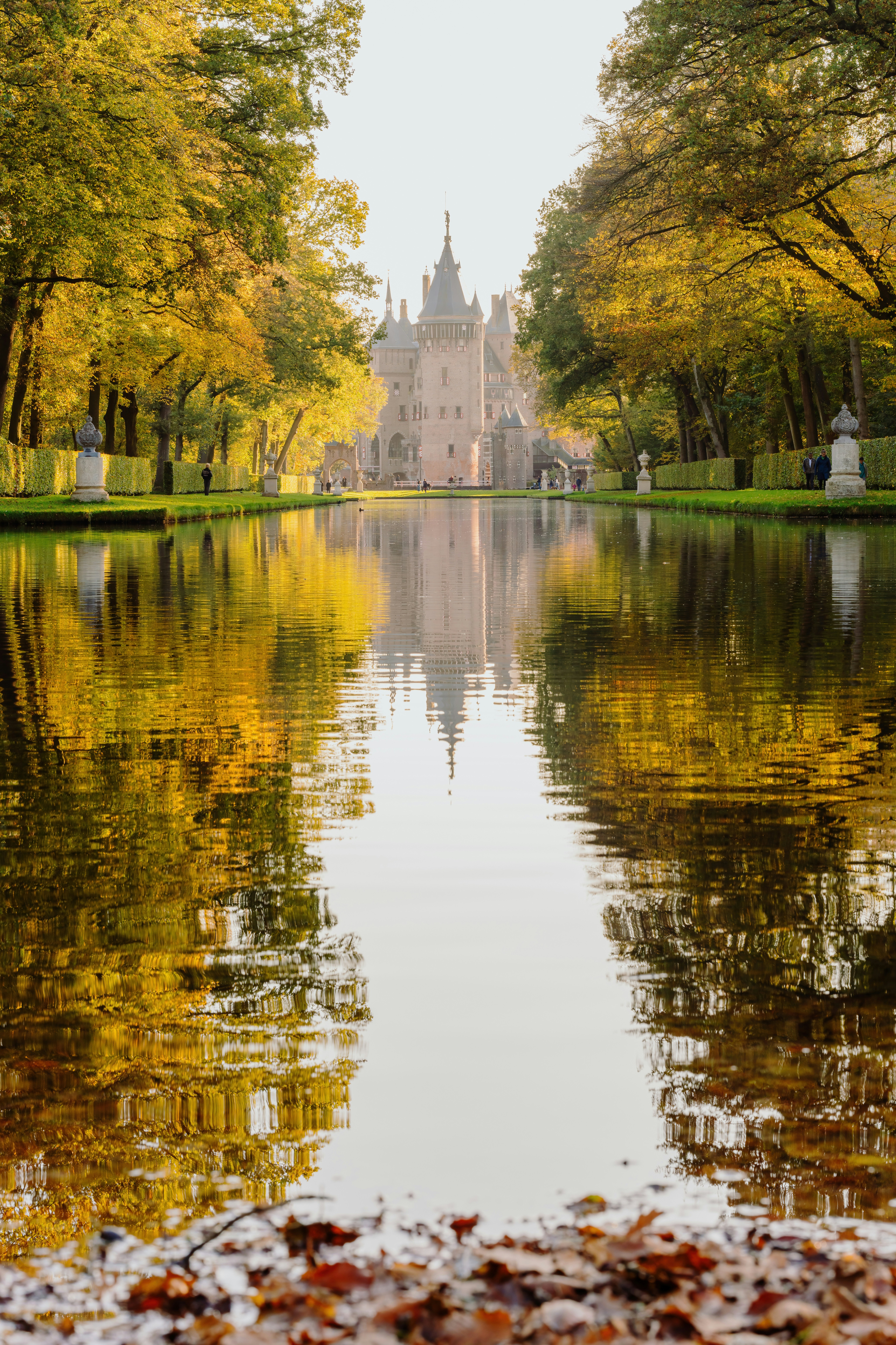 Autumn Lattice: A Castle Framed by Reflections Along a Golden Canal