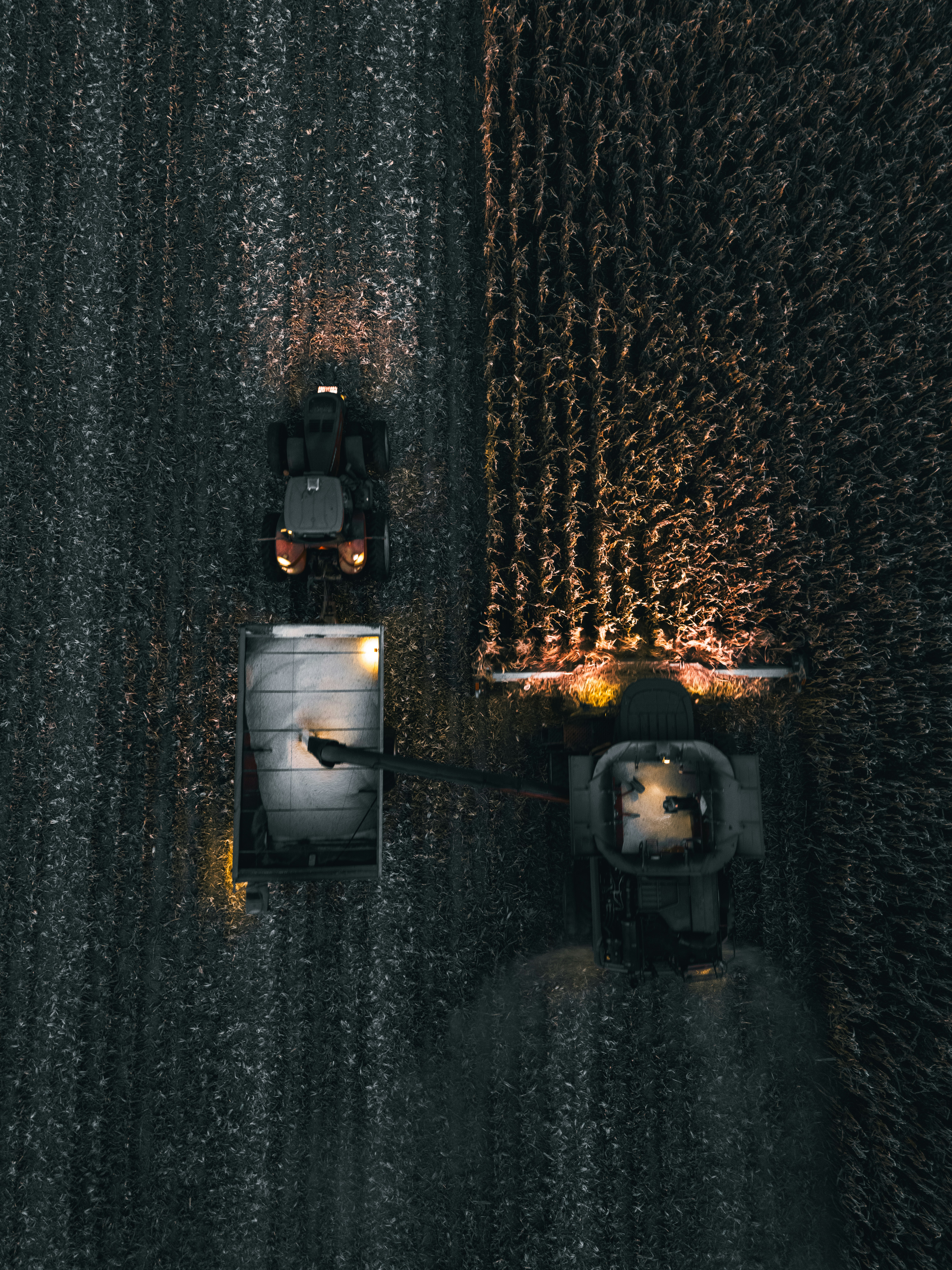 Night Harvest: Aerial View of Industrial Harvesters in a Field