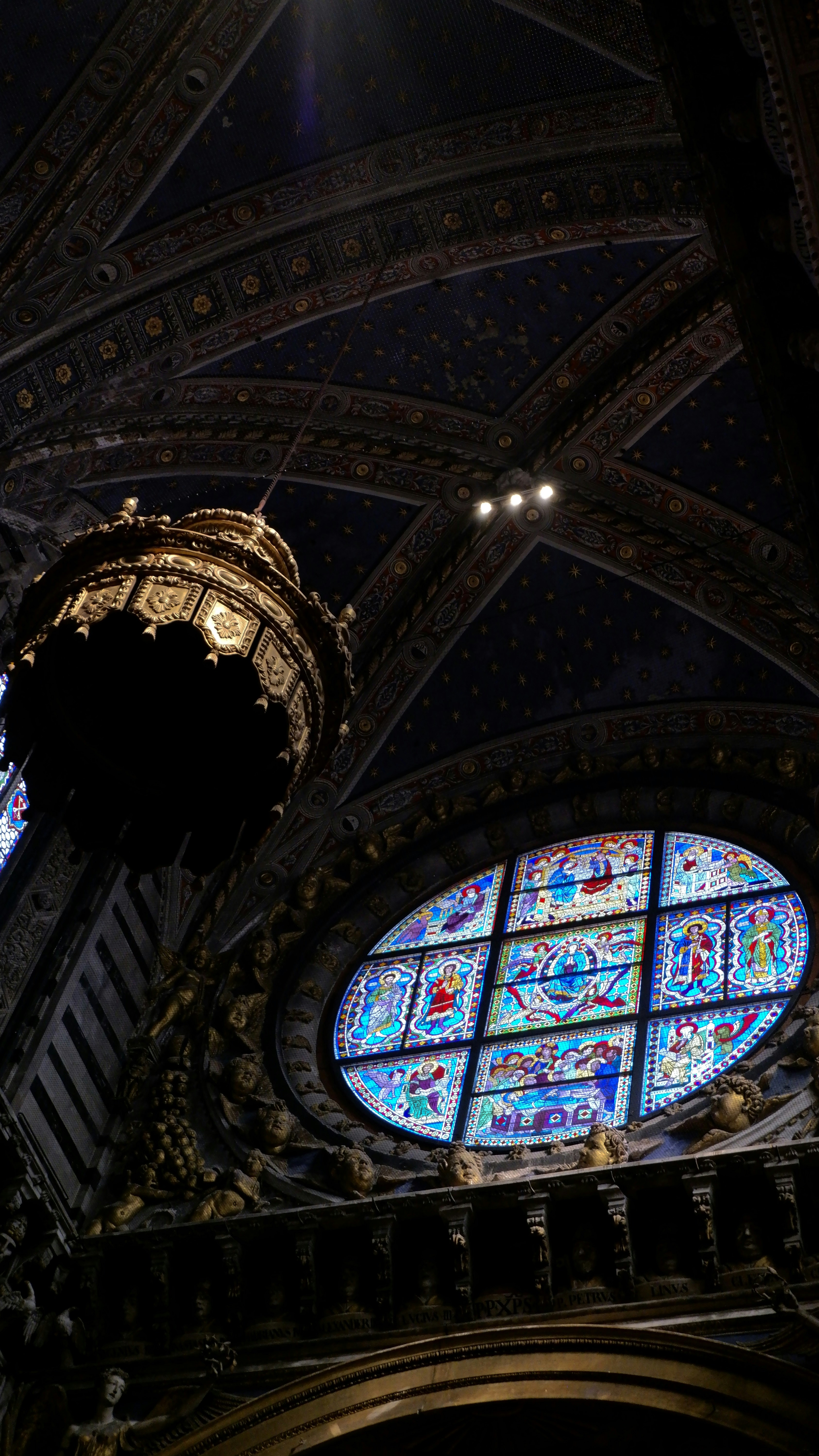 Stained Glass and Stone: Cathedral Grandeur Beneath a Hanging Lantern
