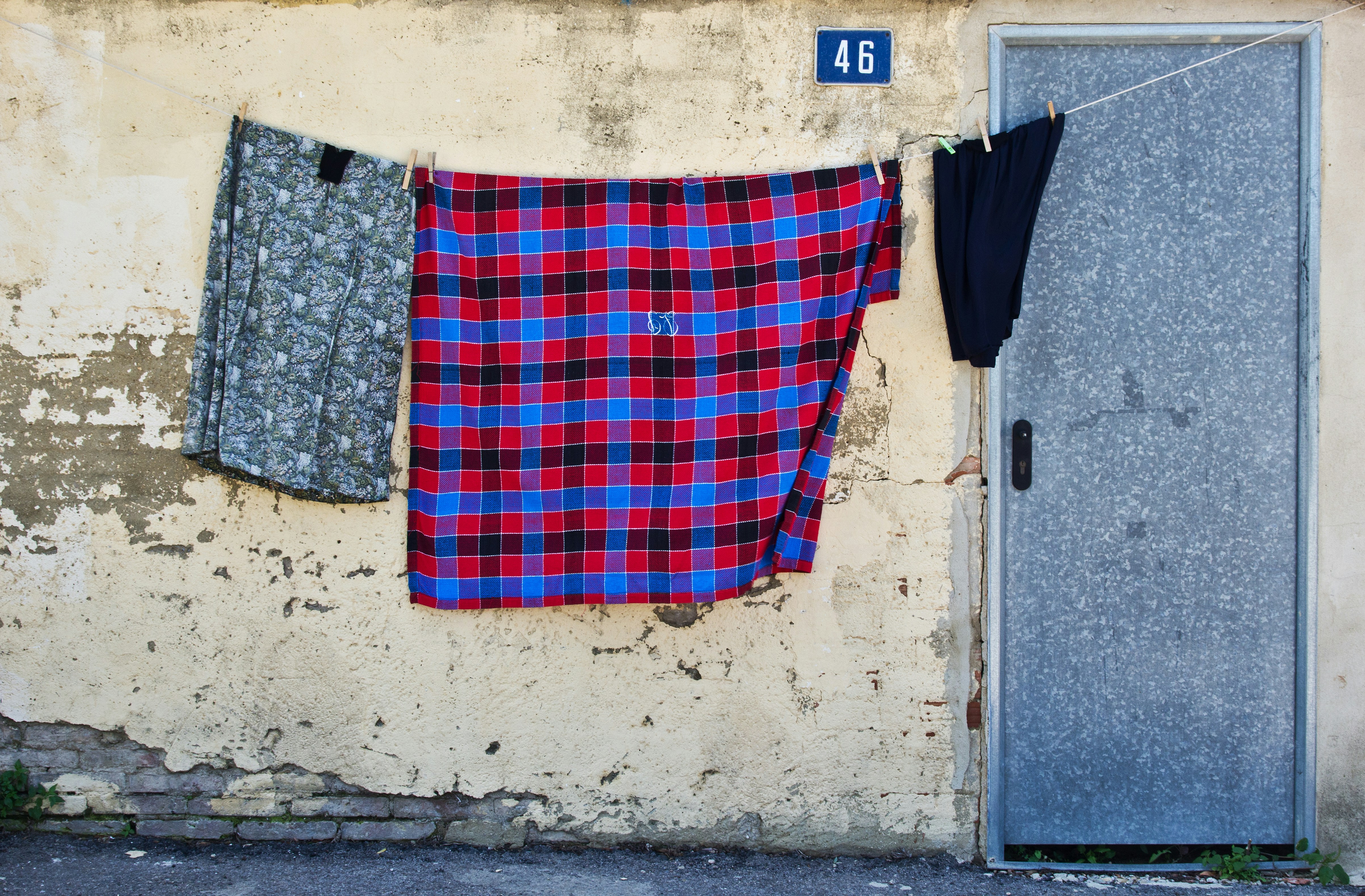 Patchwork on a Weathered Facade: Laundry Draped Across a Quiet Wall