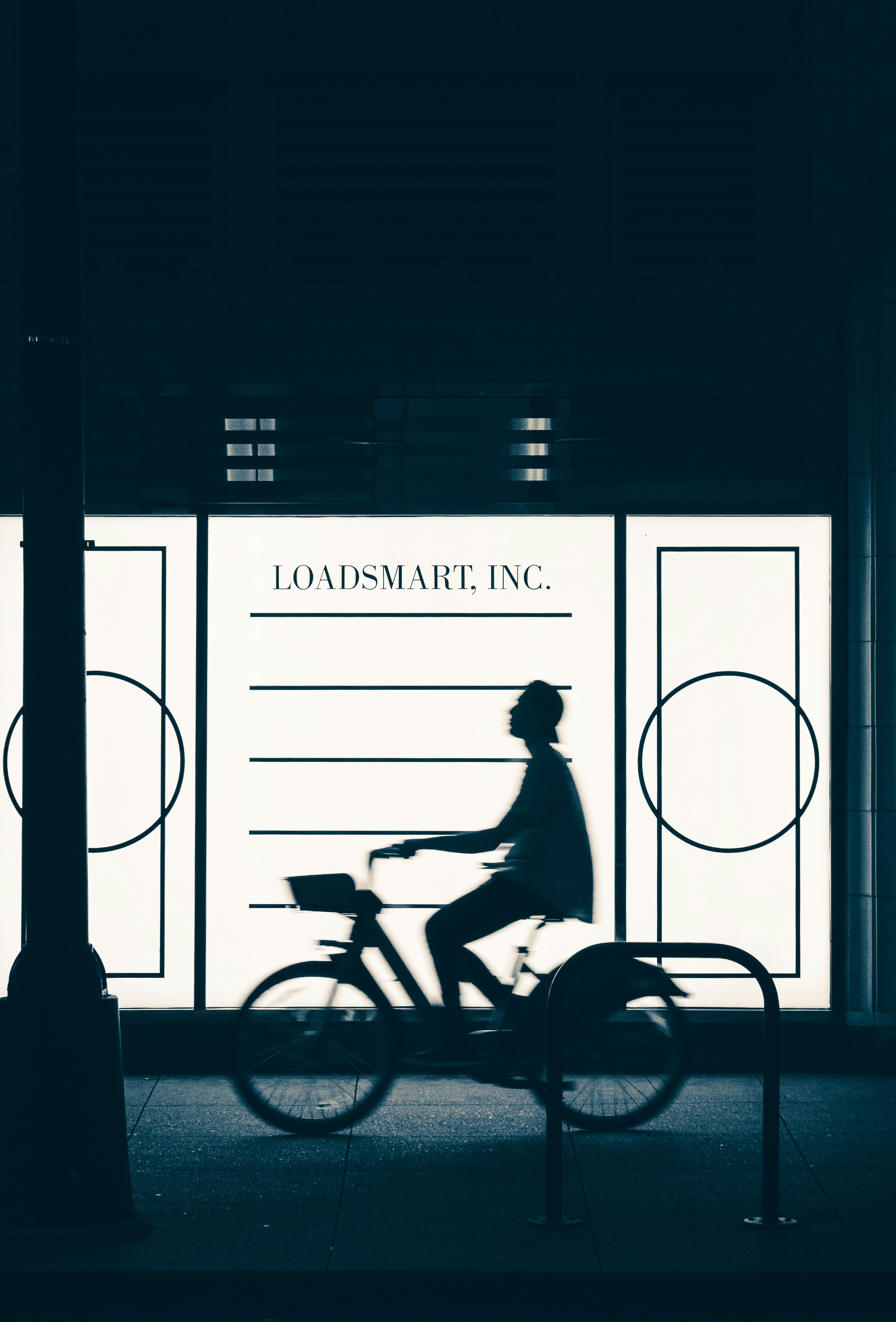 A person riding a bike in front of a store photo – Free Street ...