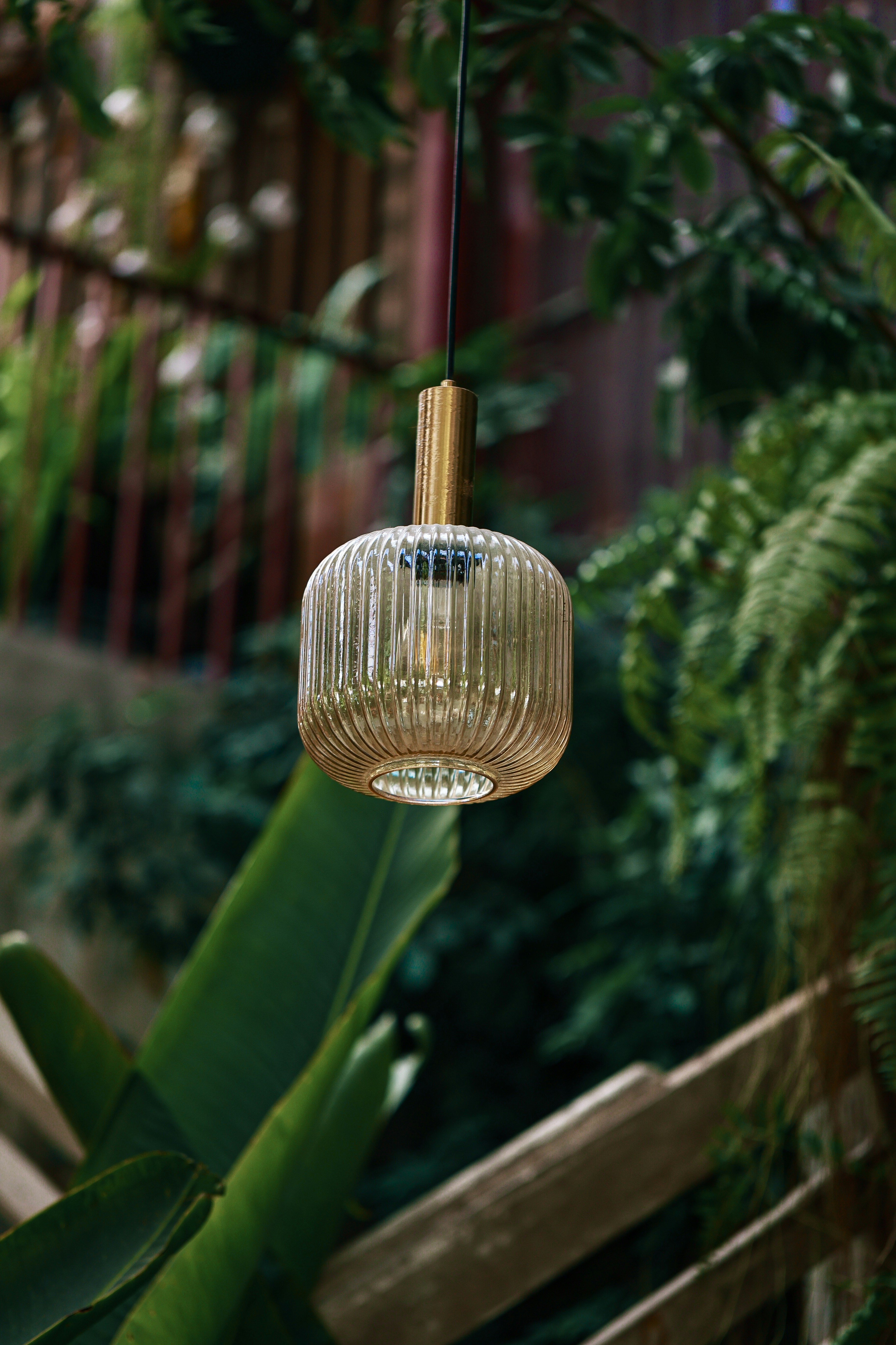 Luminous Ribbed Lantern Hanging Over a Verdant Backyard