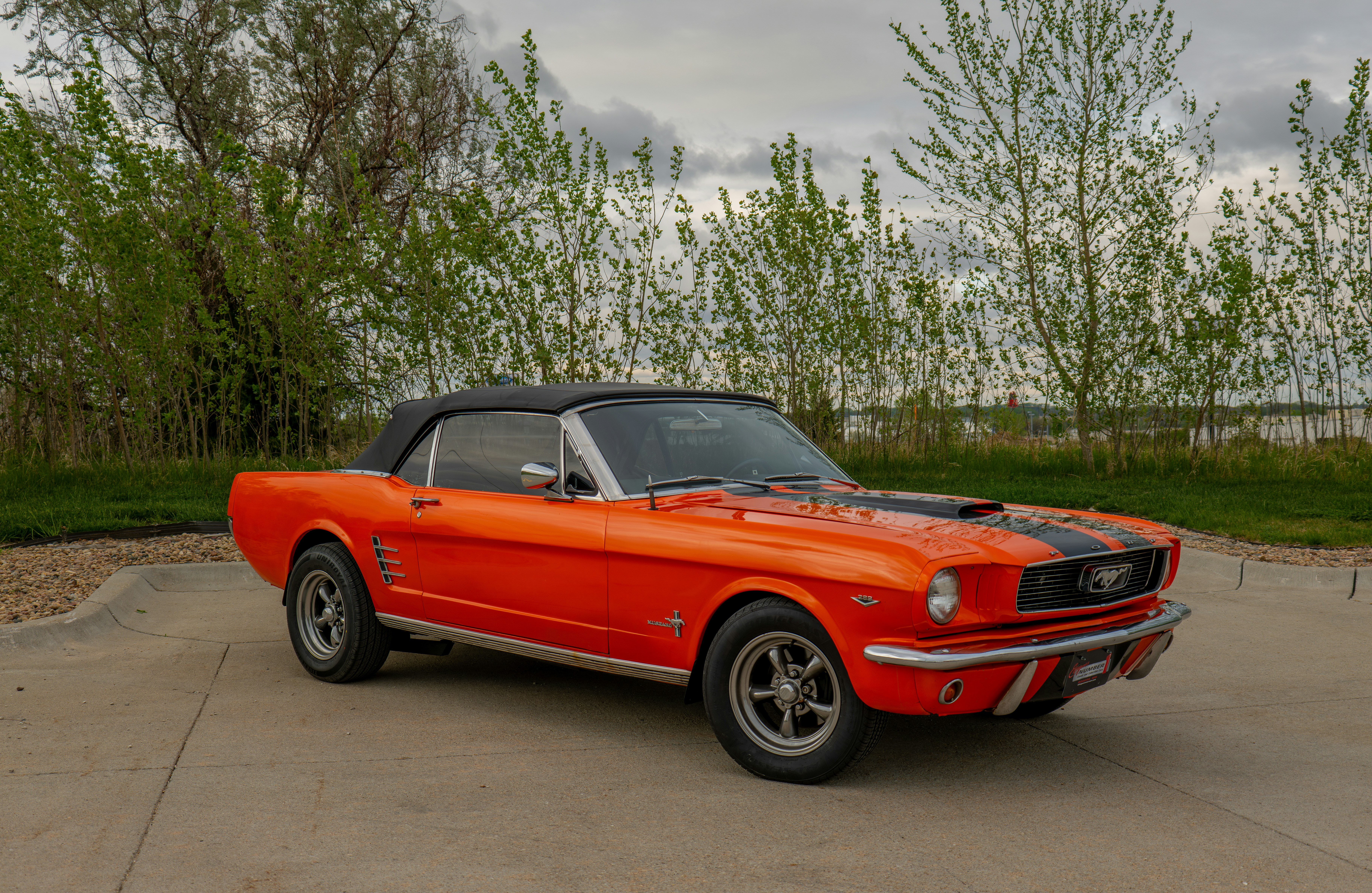 An orange mustang sitting in a parking lot photo – Free Car Image on ...