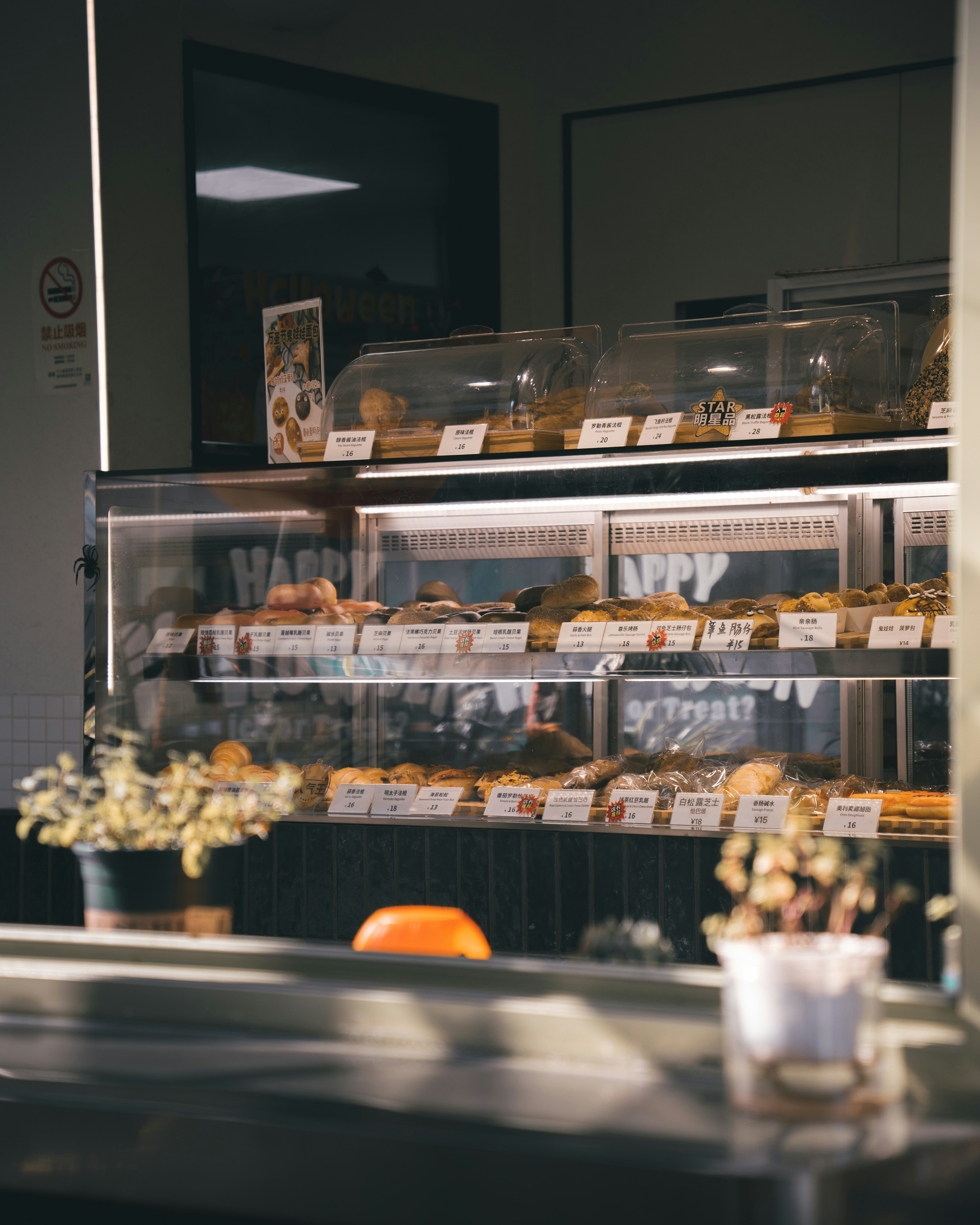 Pastries displayed behind glass in a warmly lit bakery case.