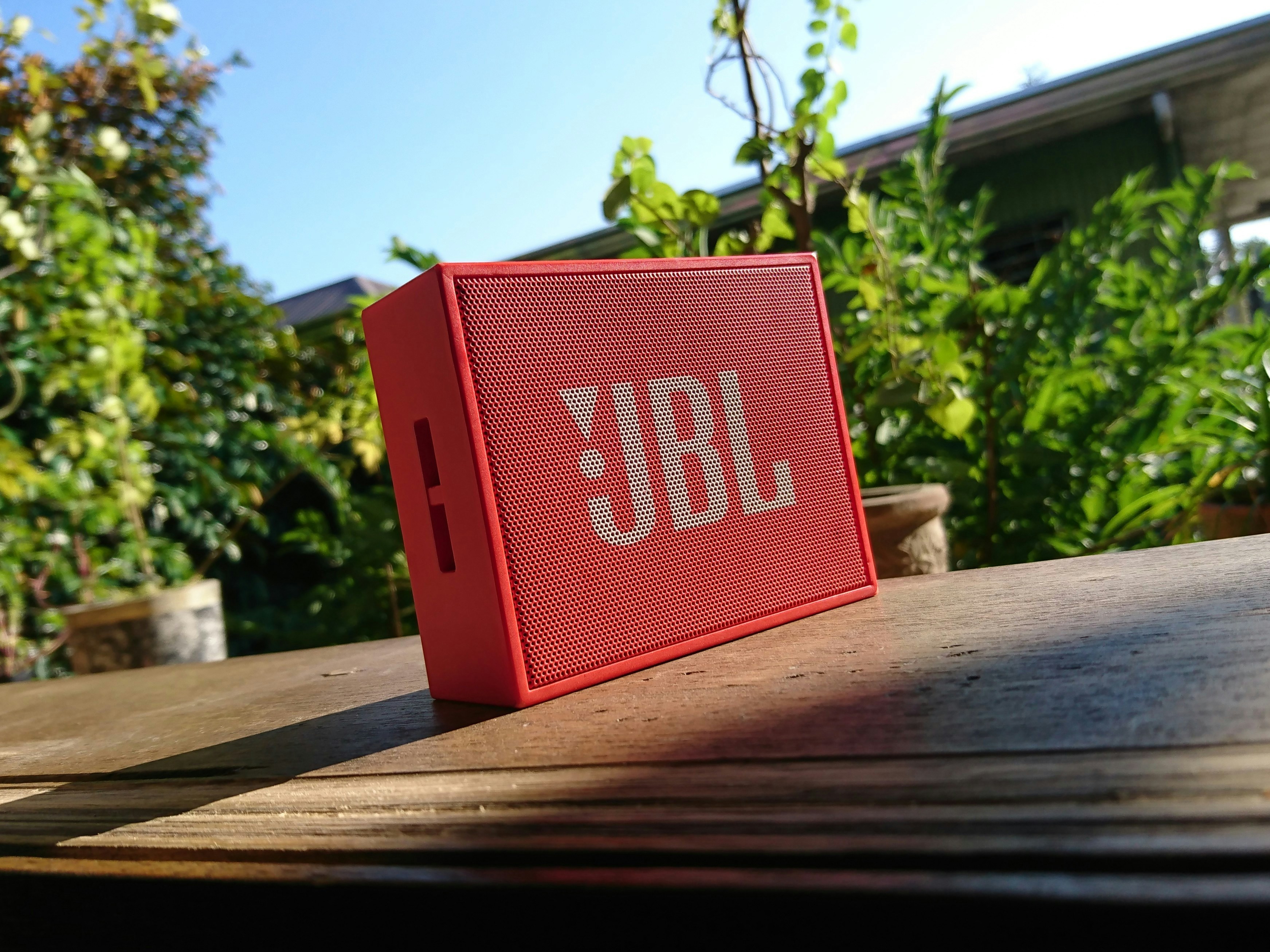 Sunlit Red JBL on a Quiet Deck: A Sharp Outdoor Moment