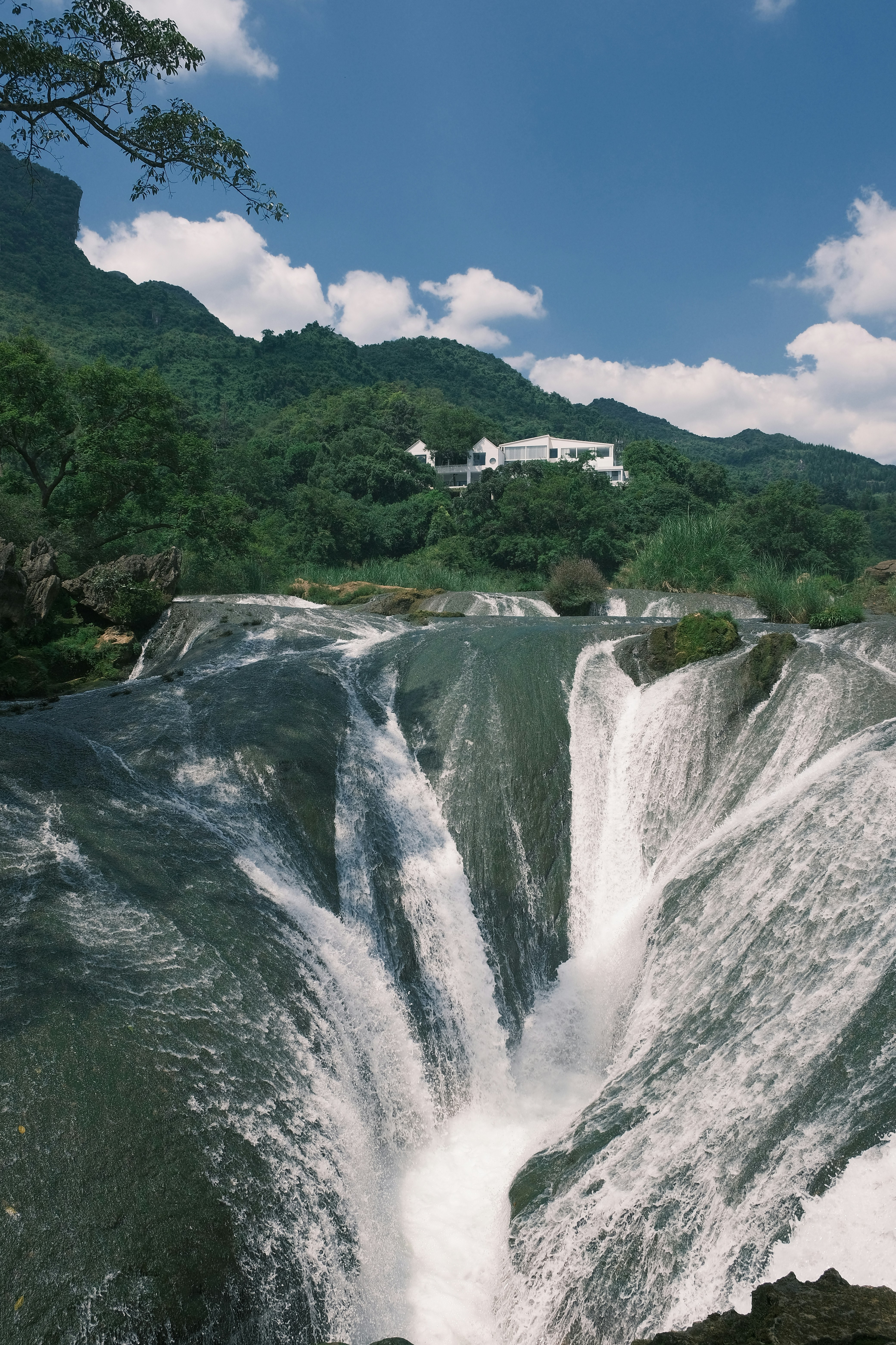 Ridgefall: Waterfall Framing a Quiet Hilltop House