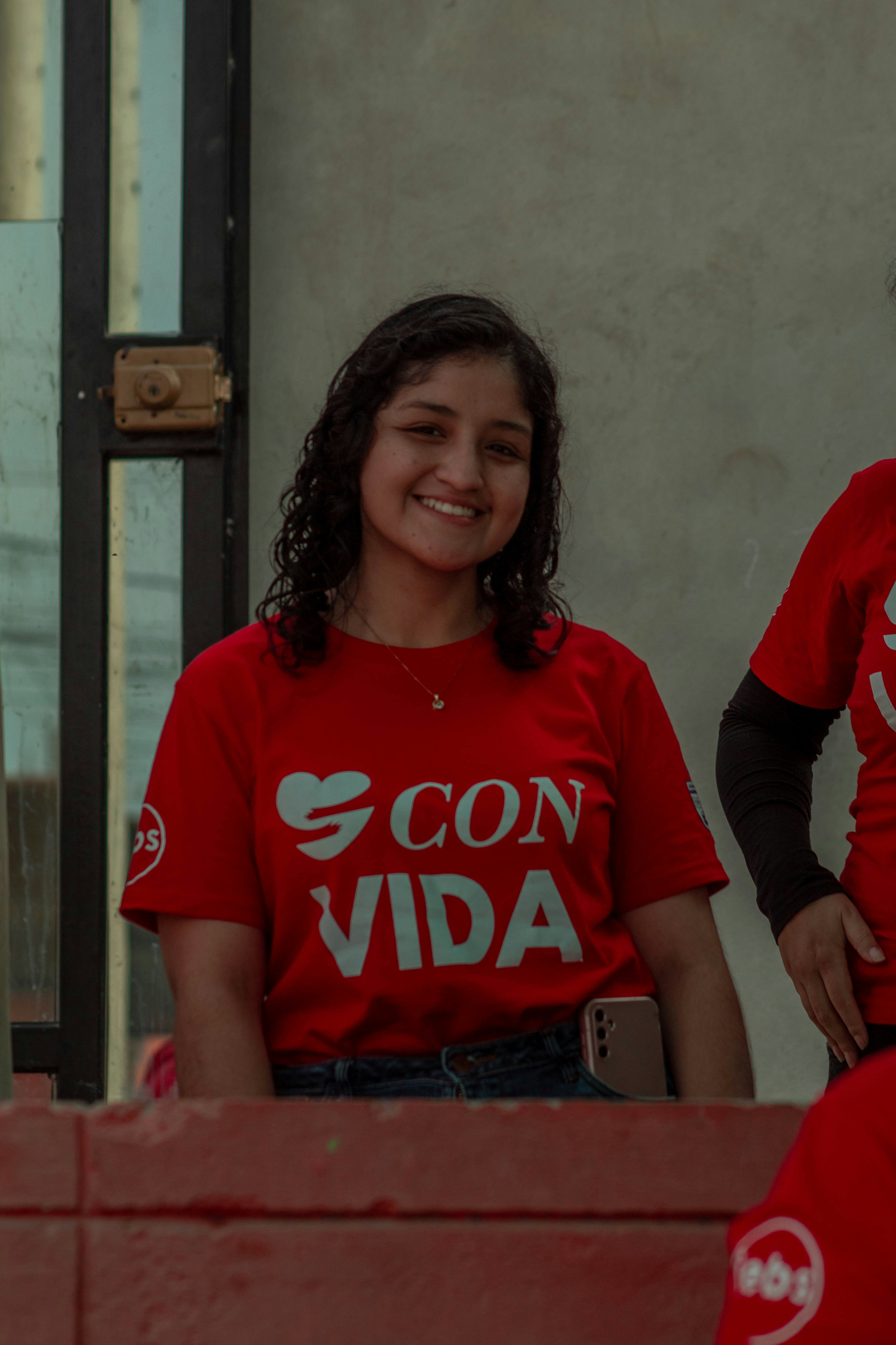 A group of people wearing red shirts standing next to each other photo ...
