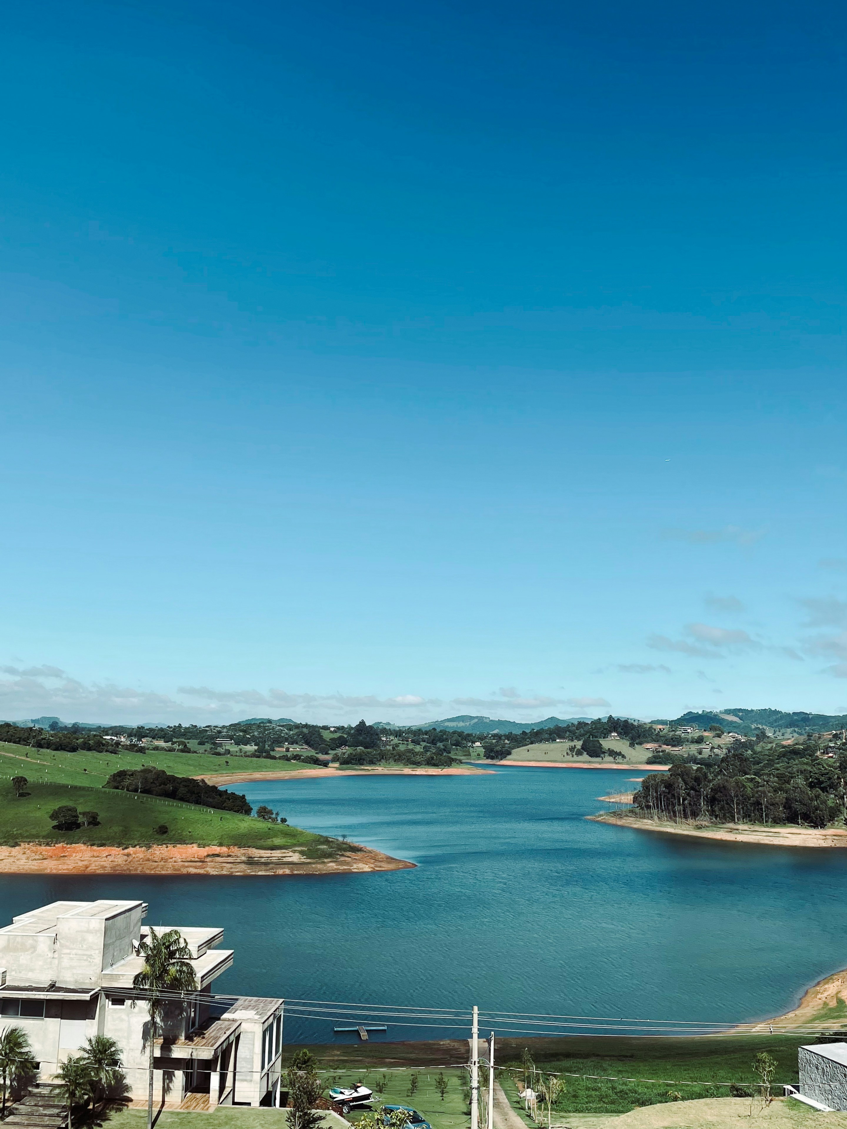 Azure Reservoir: Green Hills, Quiet Water, and a Modern Foreground