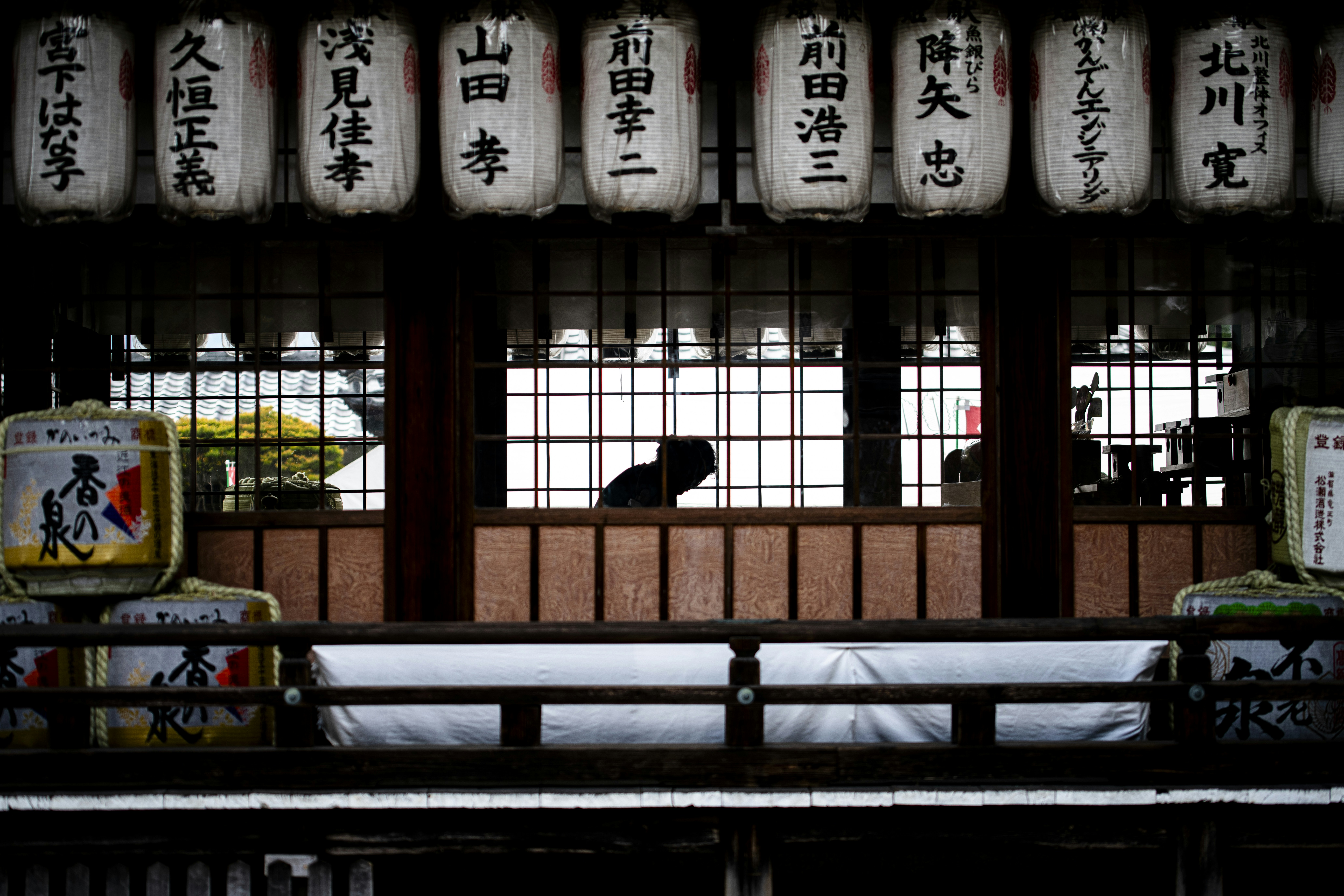 Silhouette of a Shrine Keeper: A Quiet Moment Behind the Lantern Row