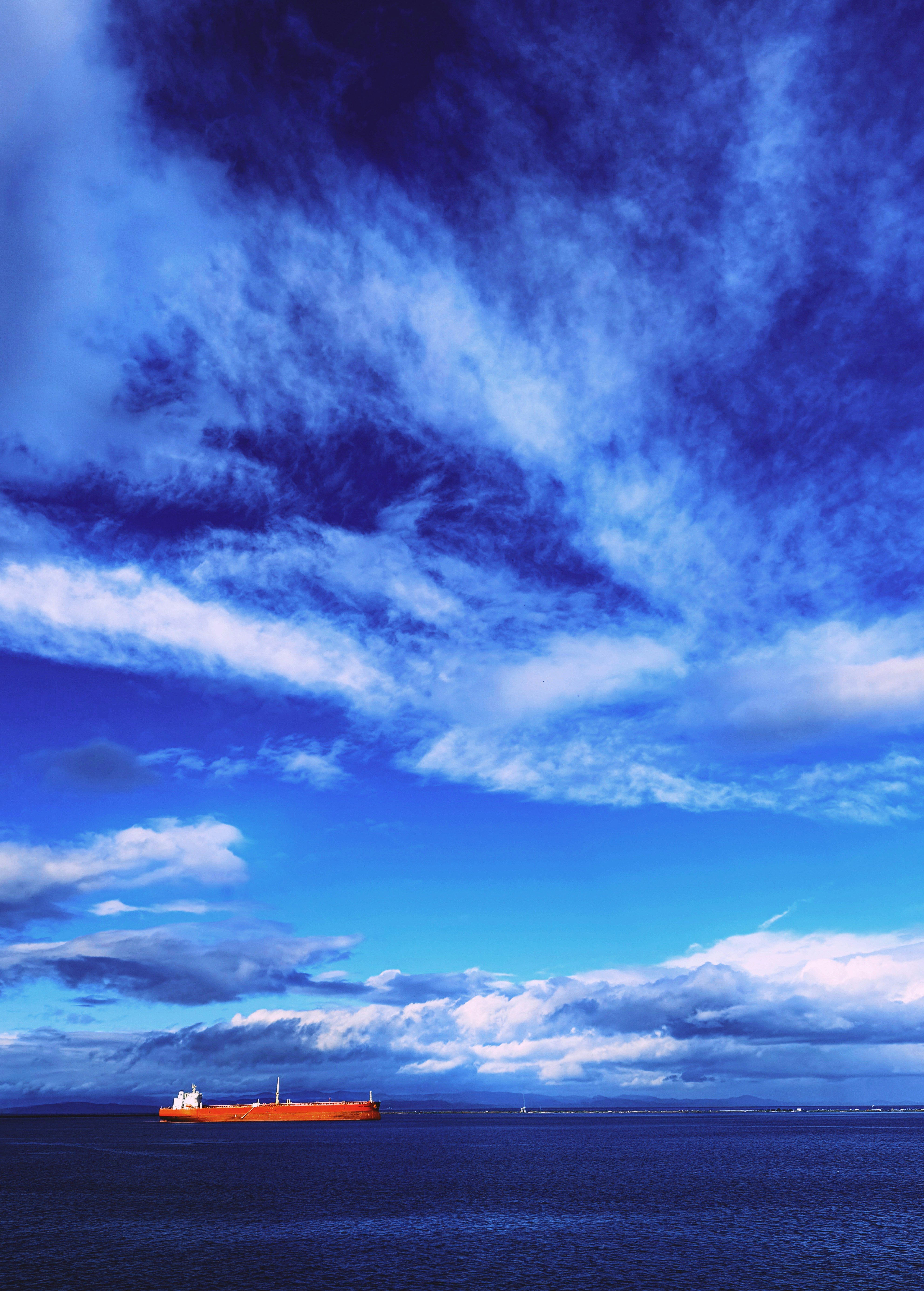 Low Horizon, Wag of a Red Hull: A Quiet Sea under Wide Blue Sky