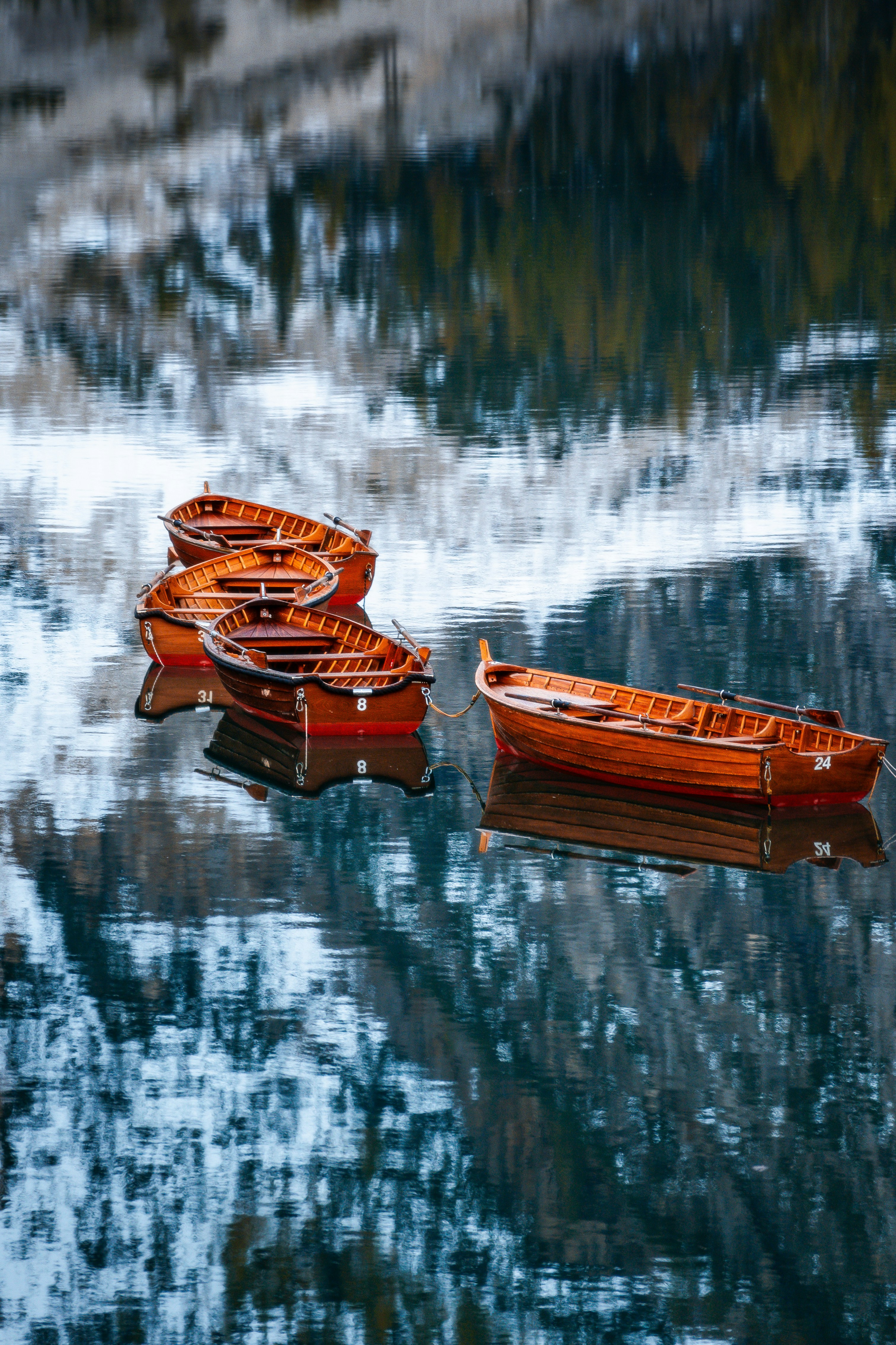 A couple of small boats floating on top of a lake photo – Free ...
