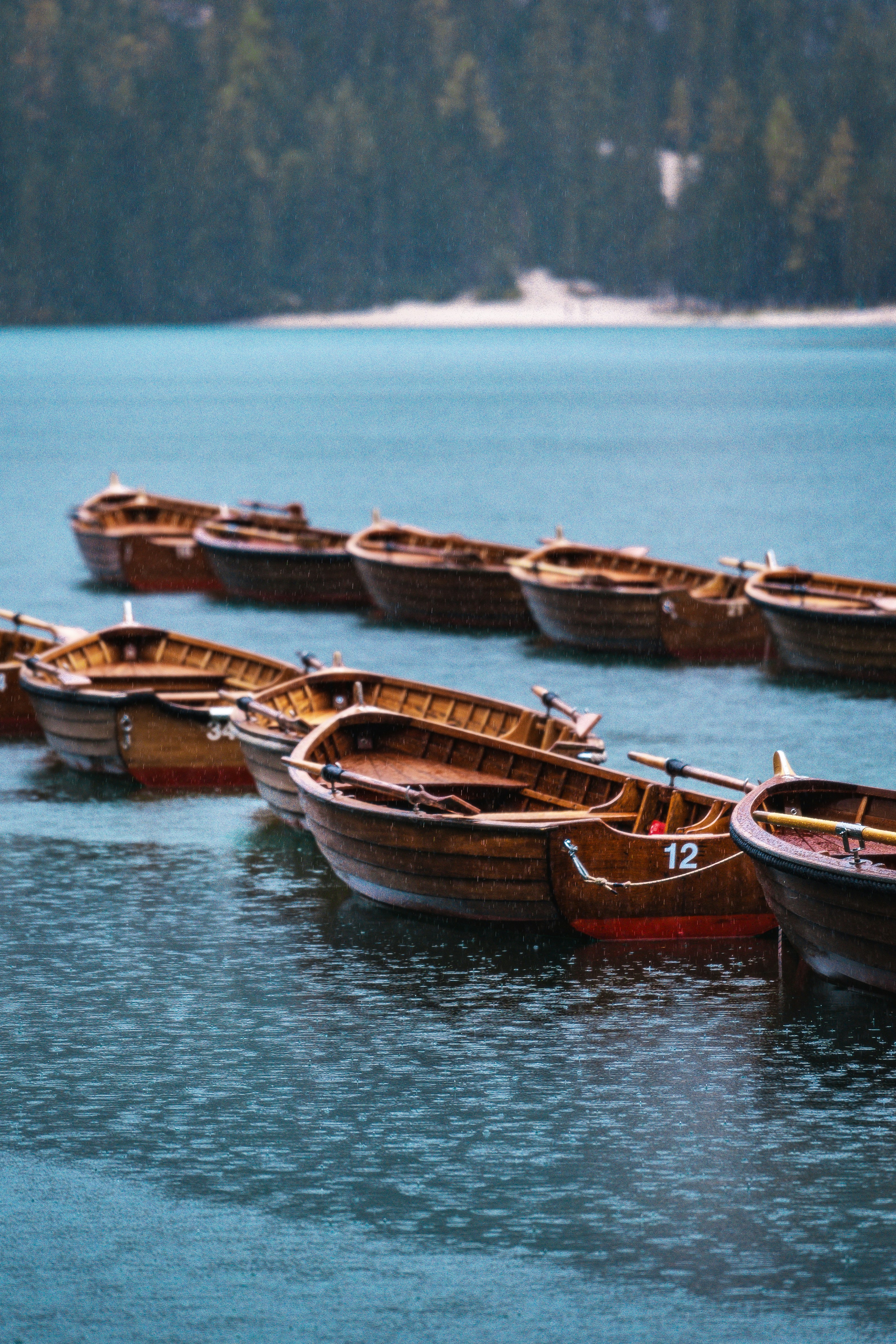 Carved Timber at Rest: Rowboats Quietly Float on Turquoise Alpine Lake