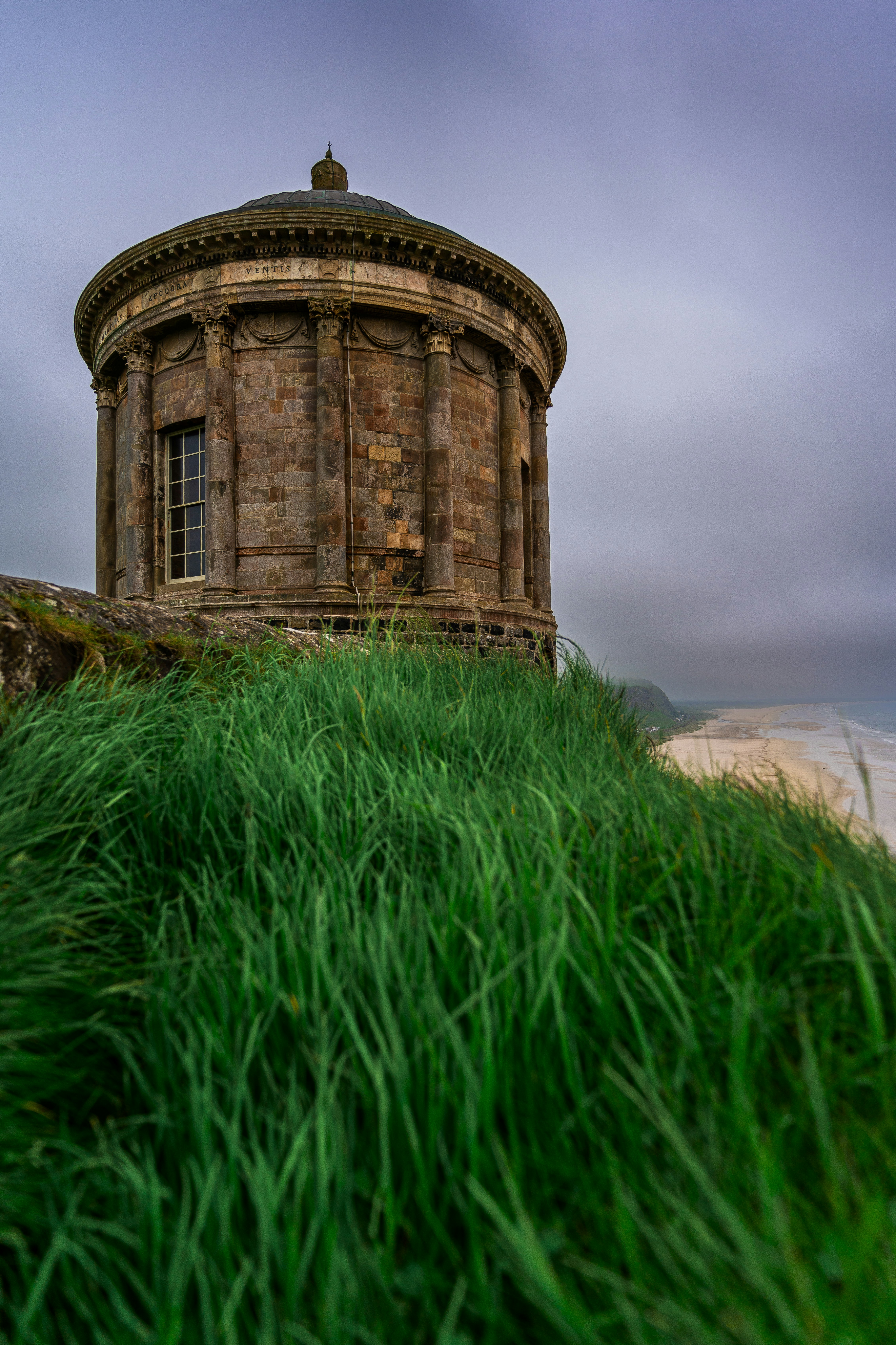 Un bâtiment rond posé au sommet d’une colline verdoyante photo – Image ...