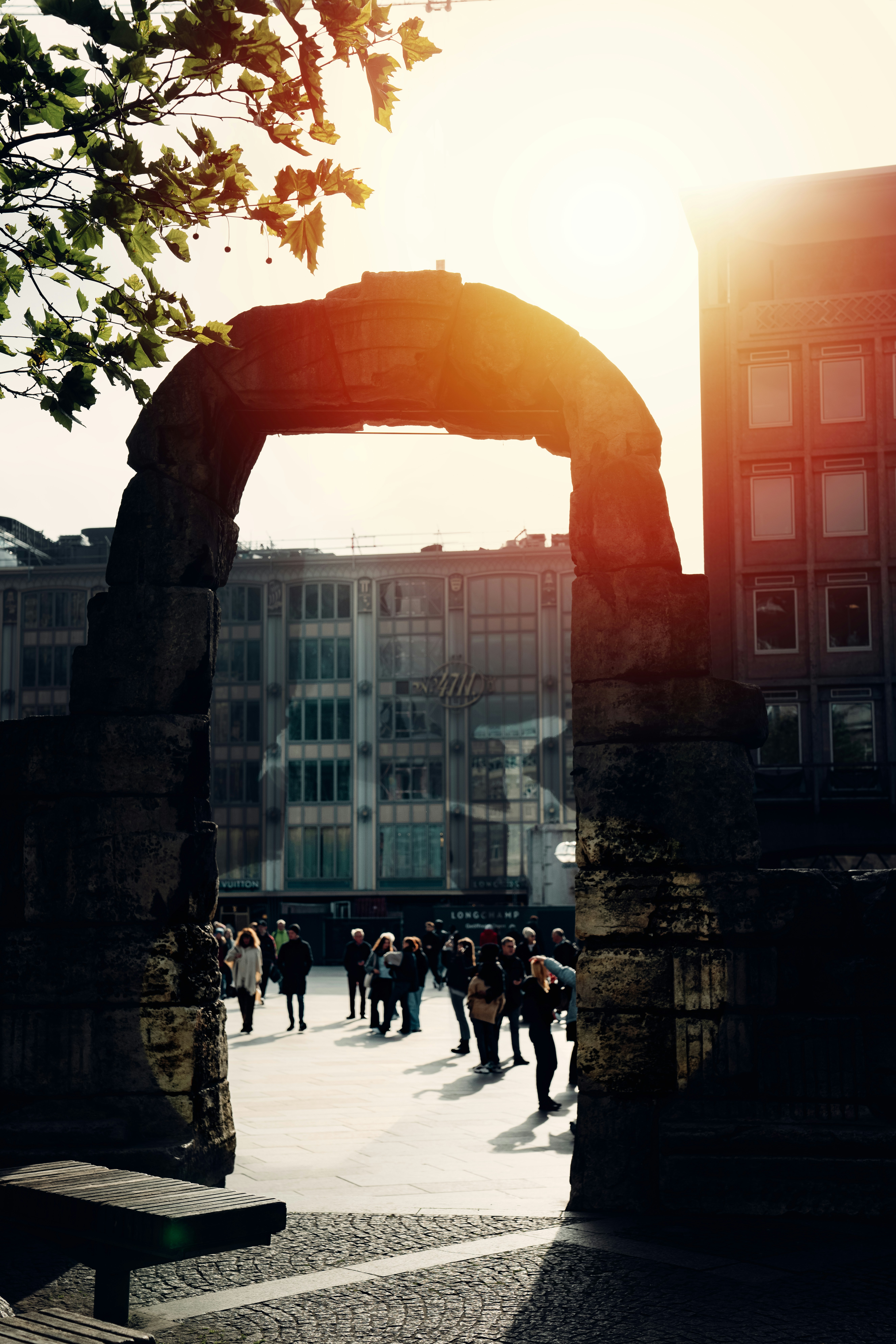 Sunlit Stone Arch Framing a Crowded City Square