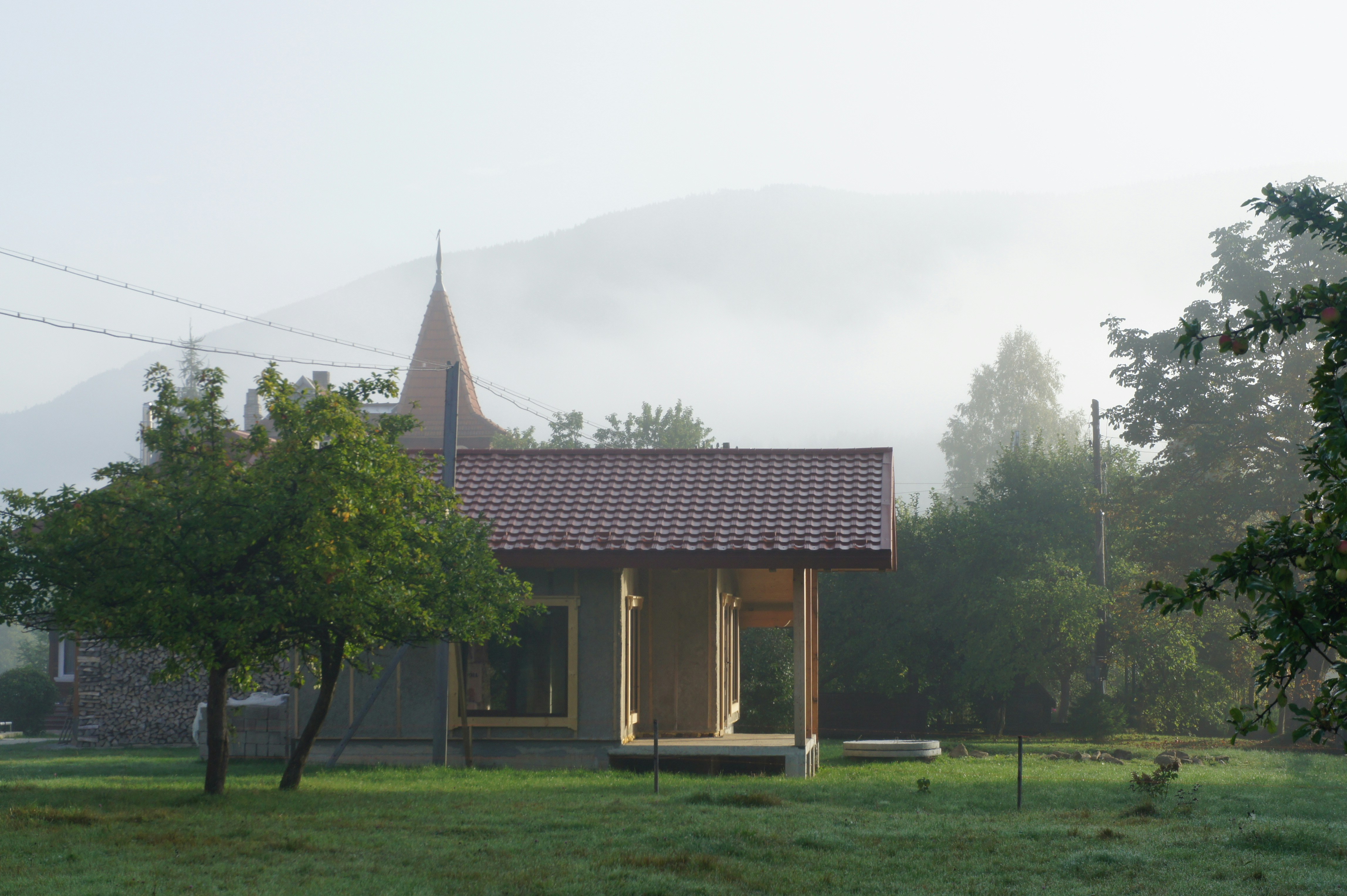 Dawn Mist Over a Quiet Cottage Framed by Garden Trees