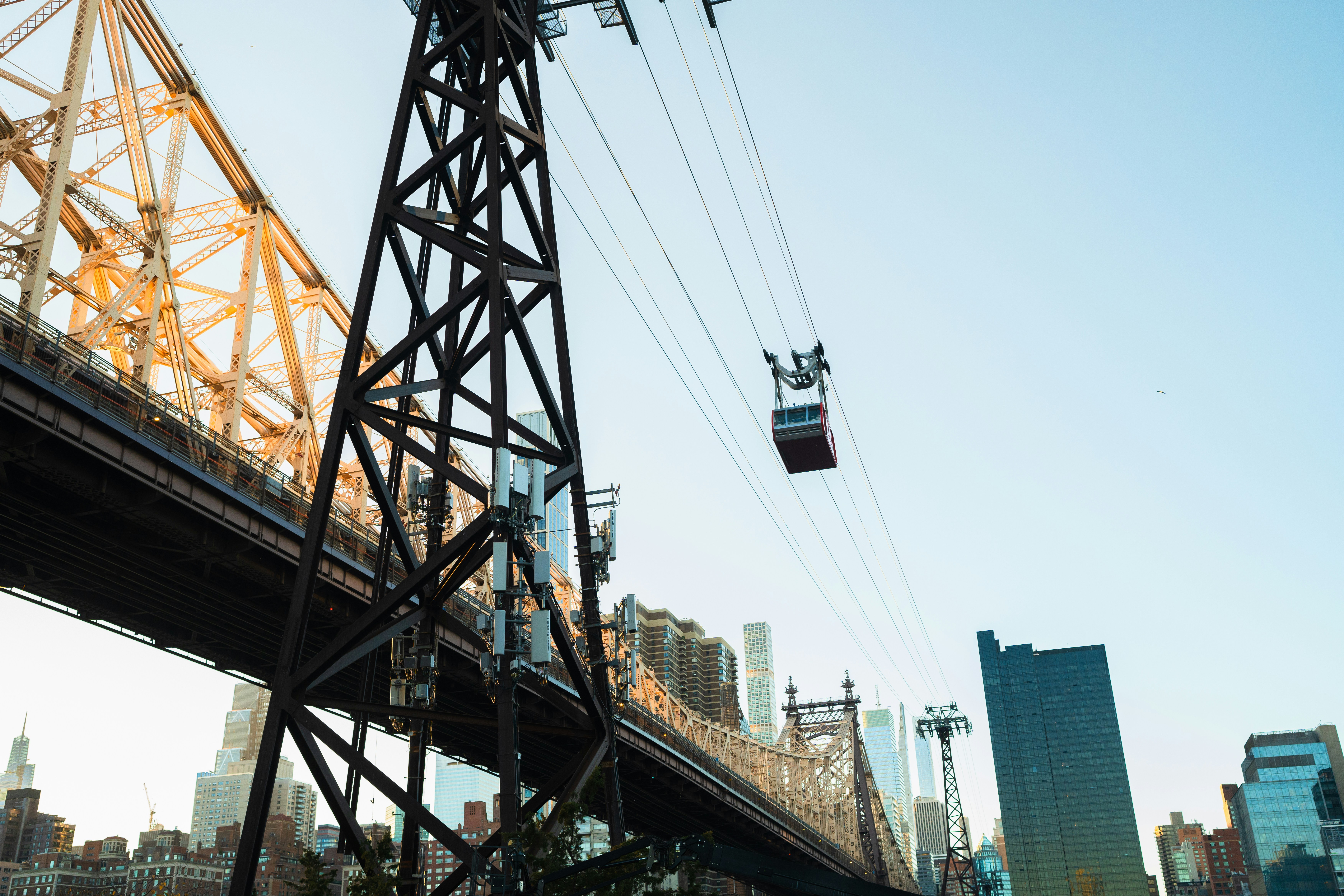 Un téléphérique passant au-dessus d’un pont avec une ville en arrière ...