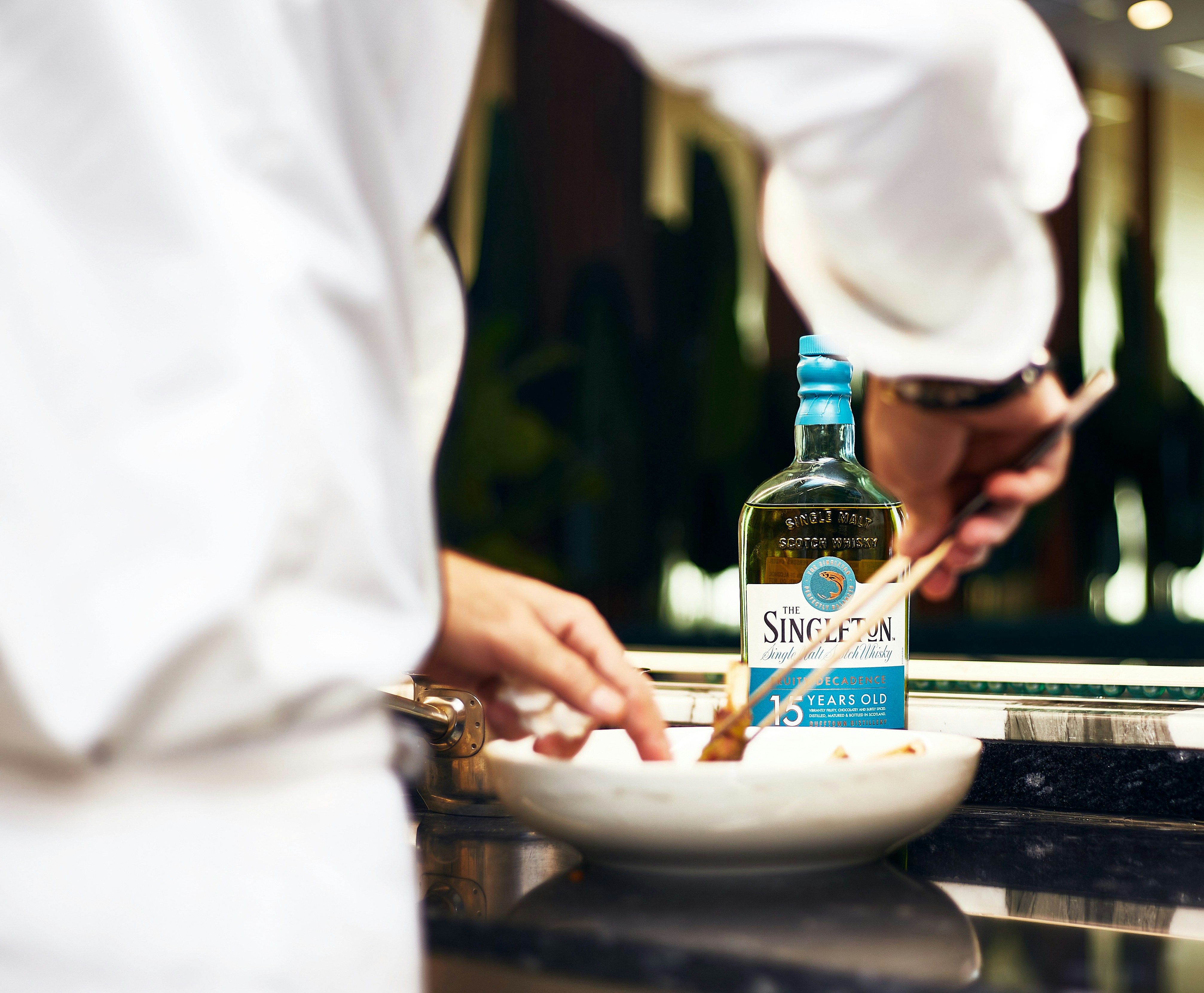 Blended Spirits at the Bar: A Chef at Work with a Bottled Label in Focus