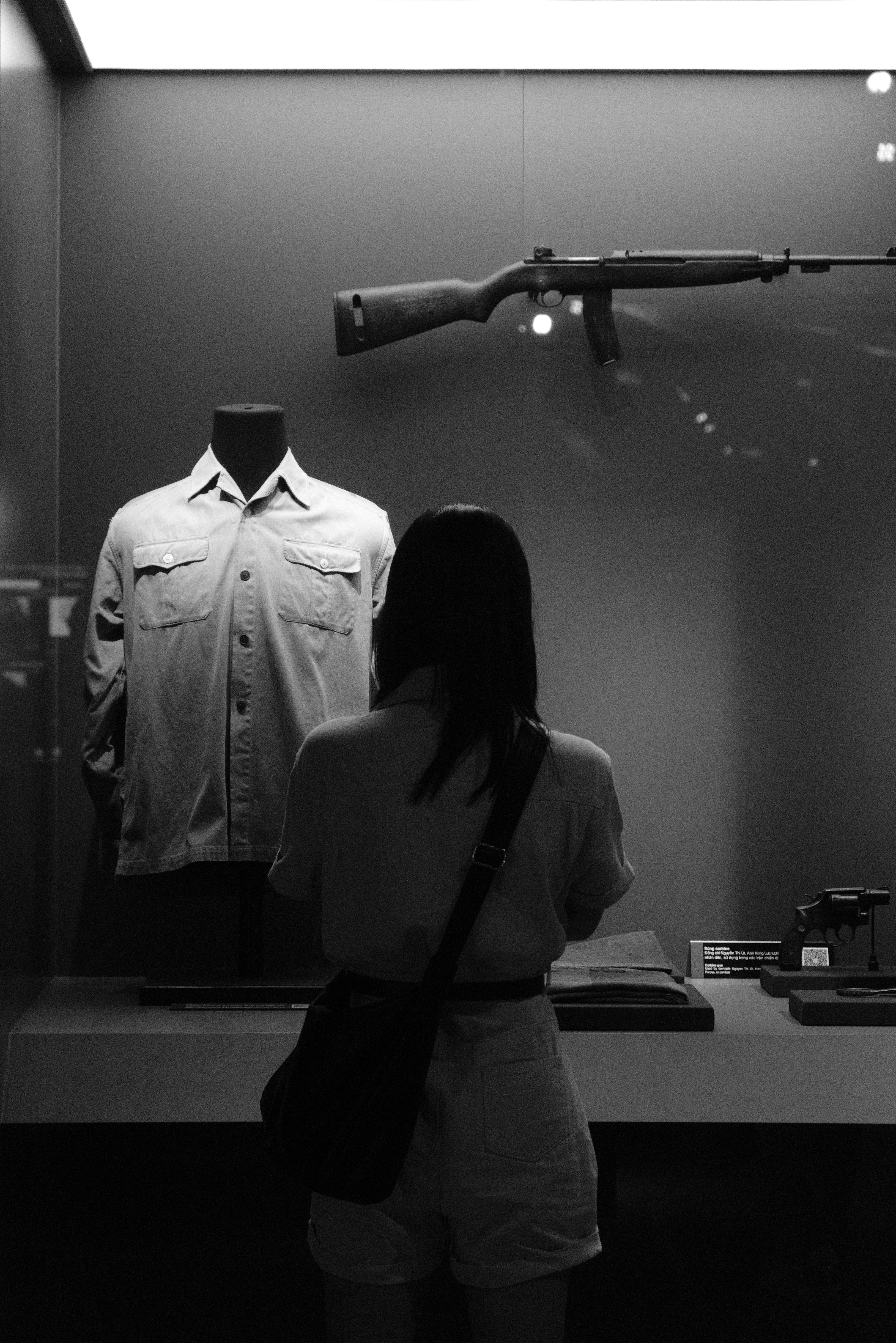 A woman standing in front of a display of guns photo – Free Travel ...