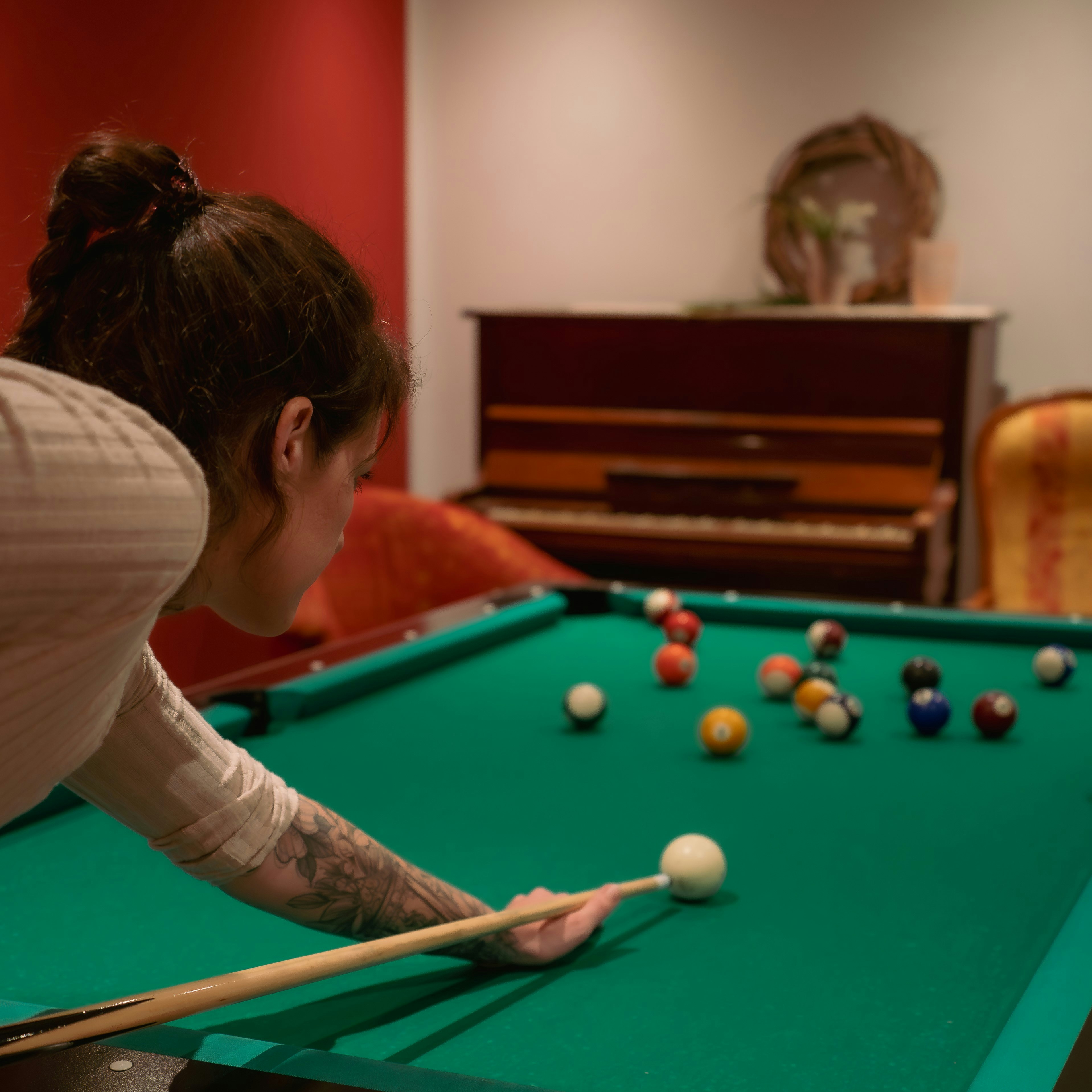 A woman leaning over a pool table with a cue in her hand photo – Free ...