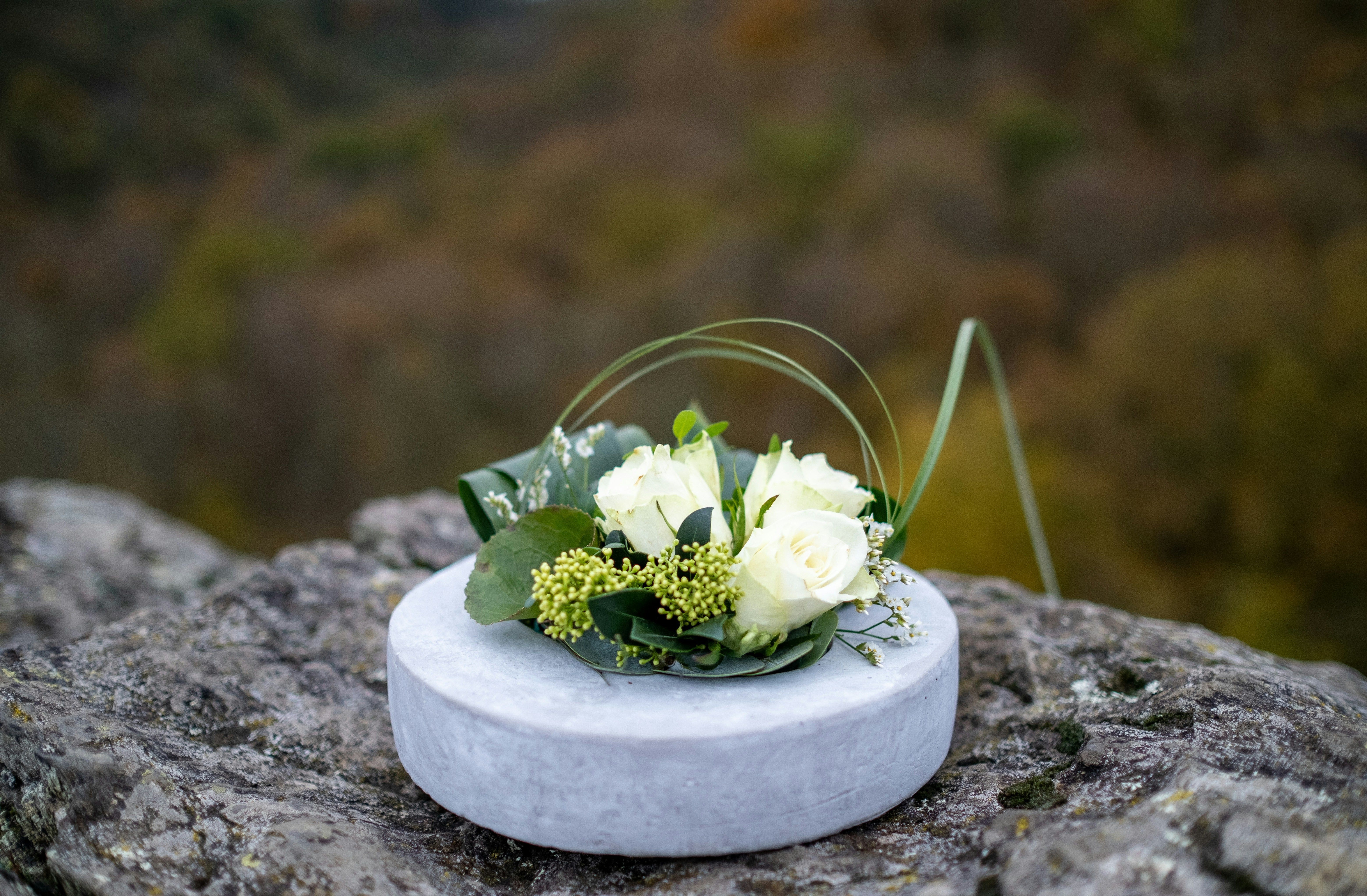 Stone pedestal bouquet: delicate whites atop weathered rock