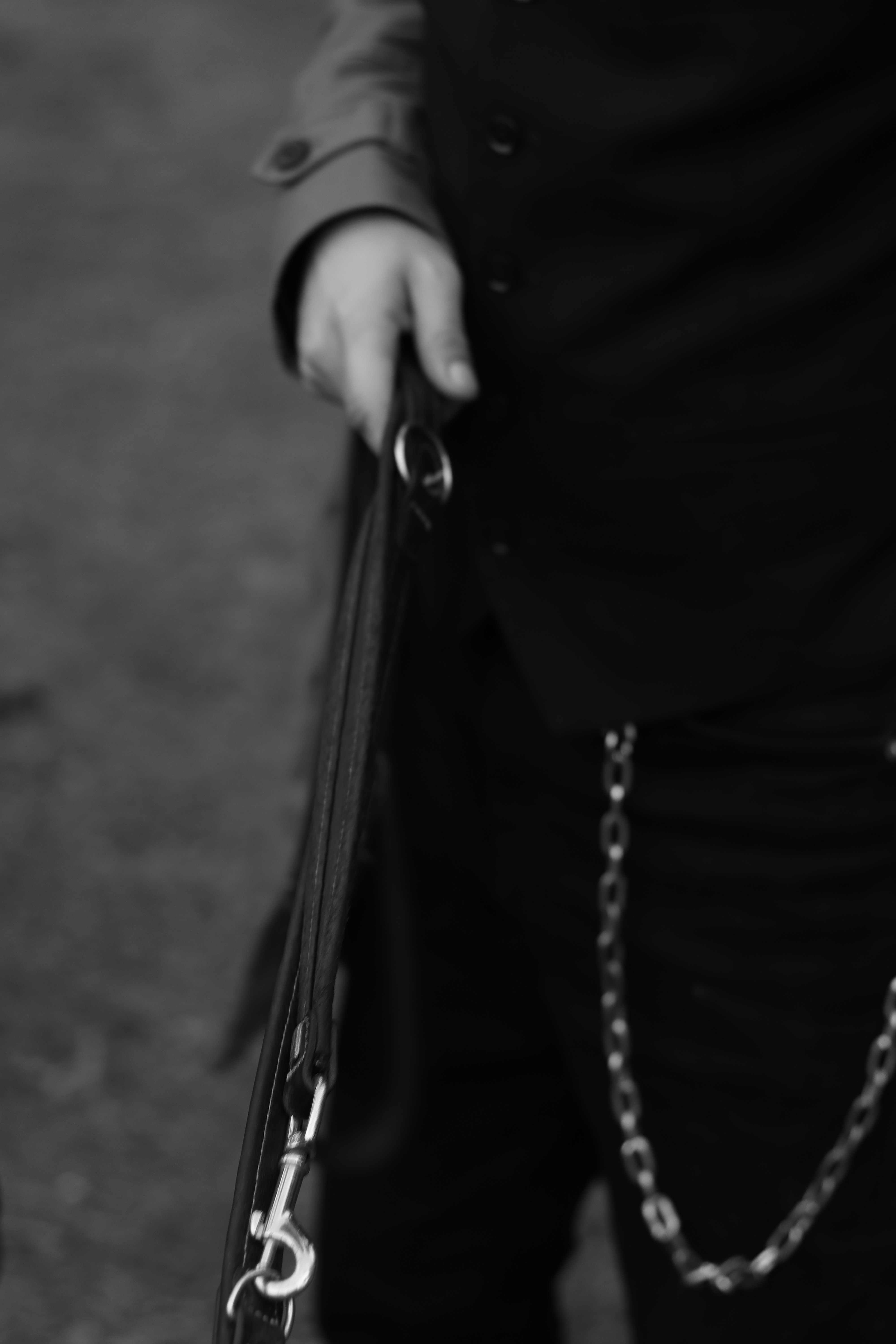 A black and white photo of a person holding a handbag