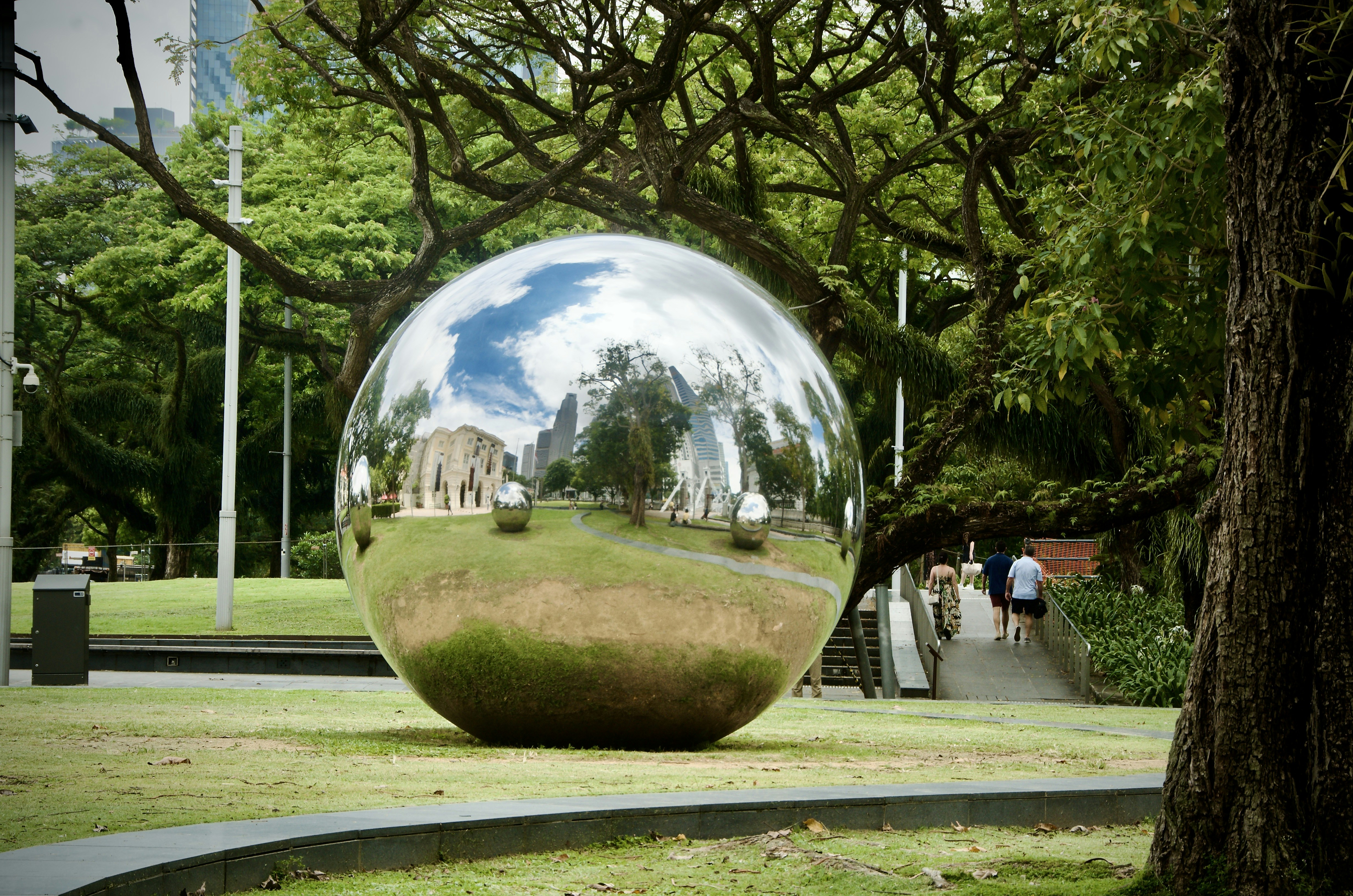 A large metal ball sitting in the middle of a park photo – Free Human ...
