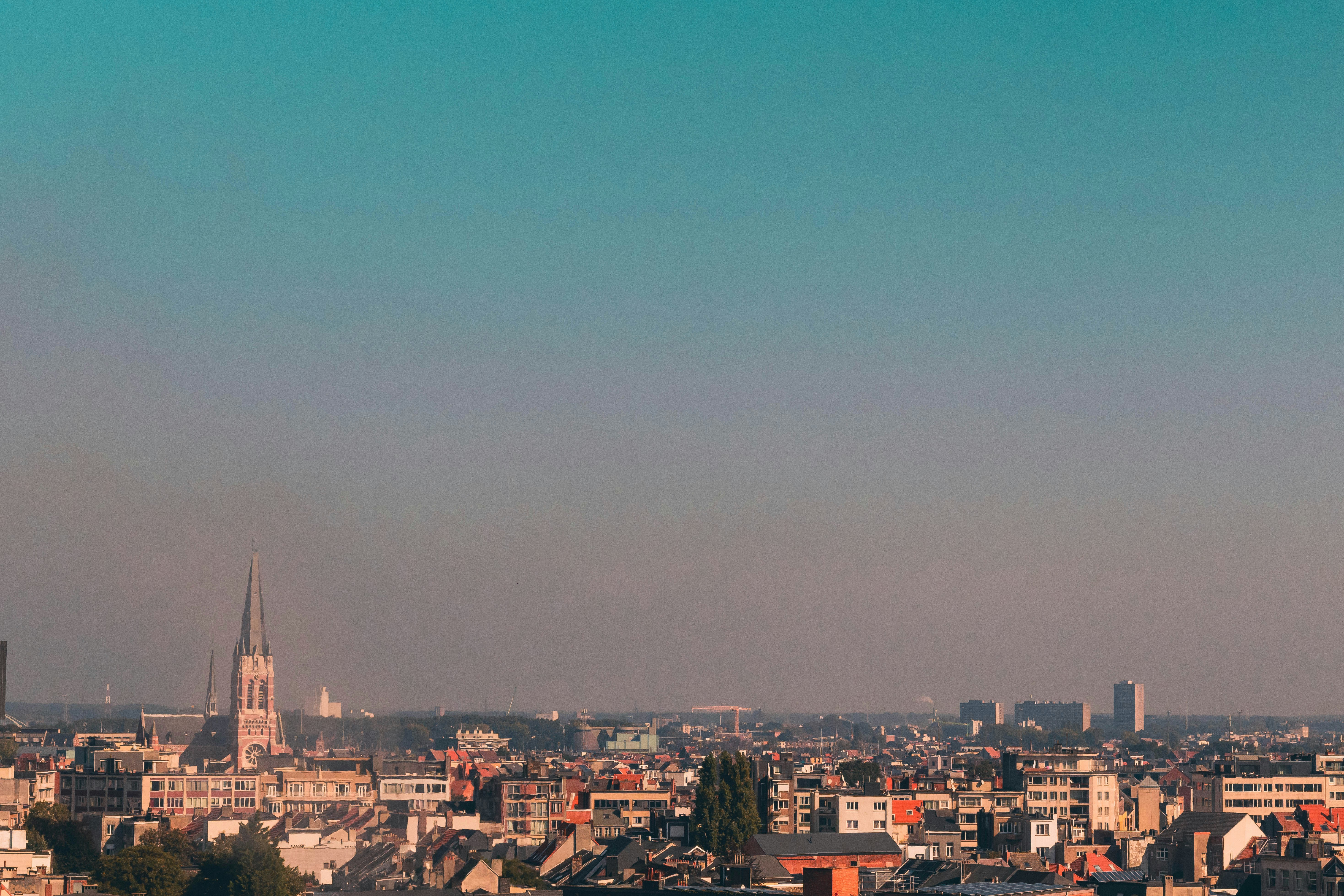Cityscape with scattered tall buildings under a clear blue sky.