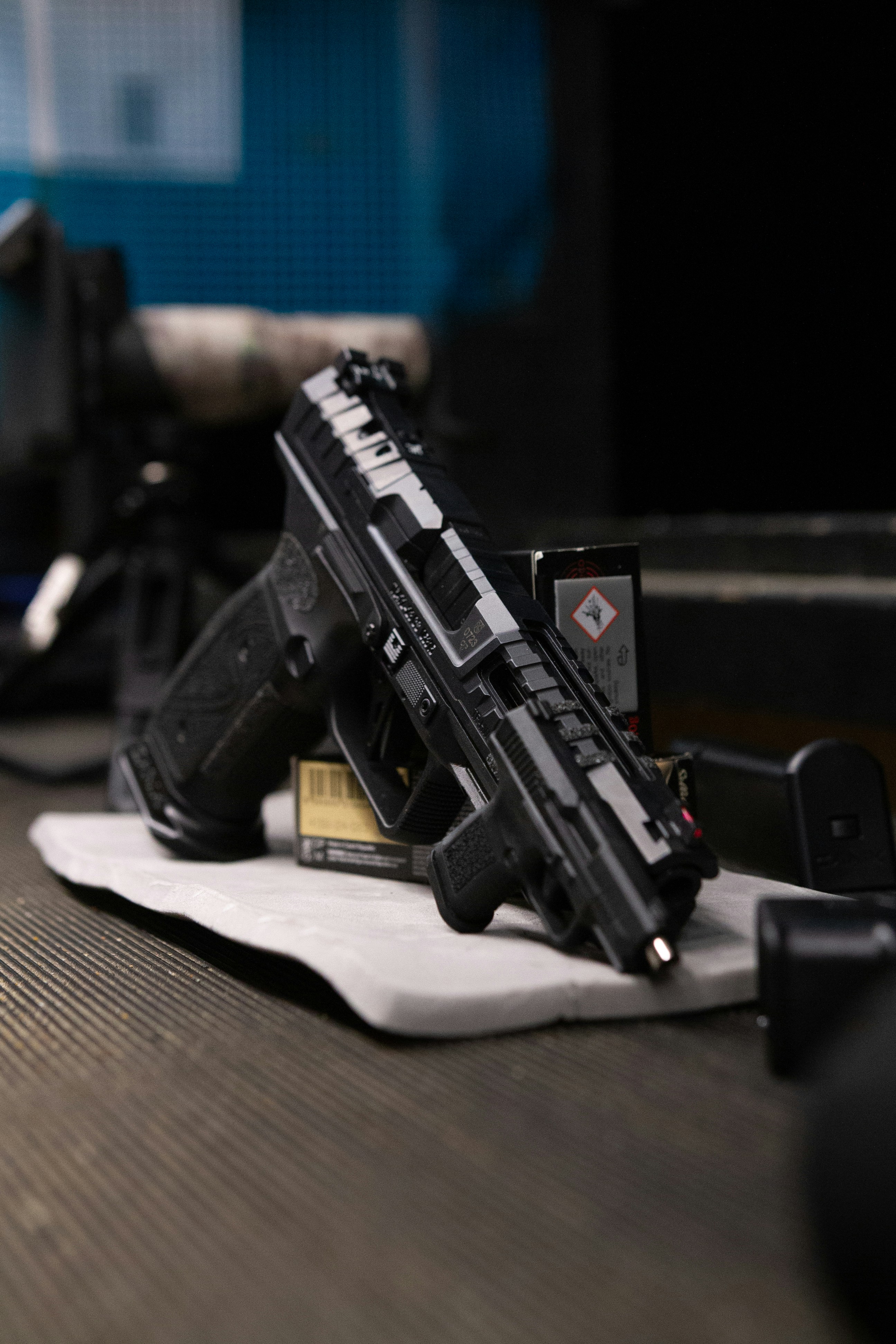 Workbench Stillness: A Modern Pistol on White Cloth Under Studio Light