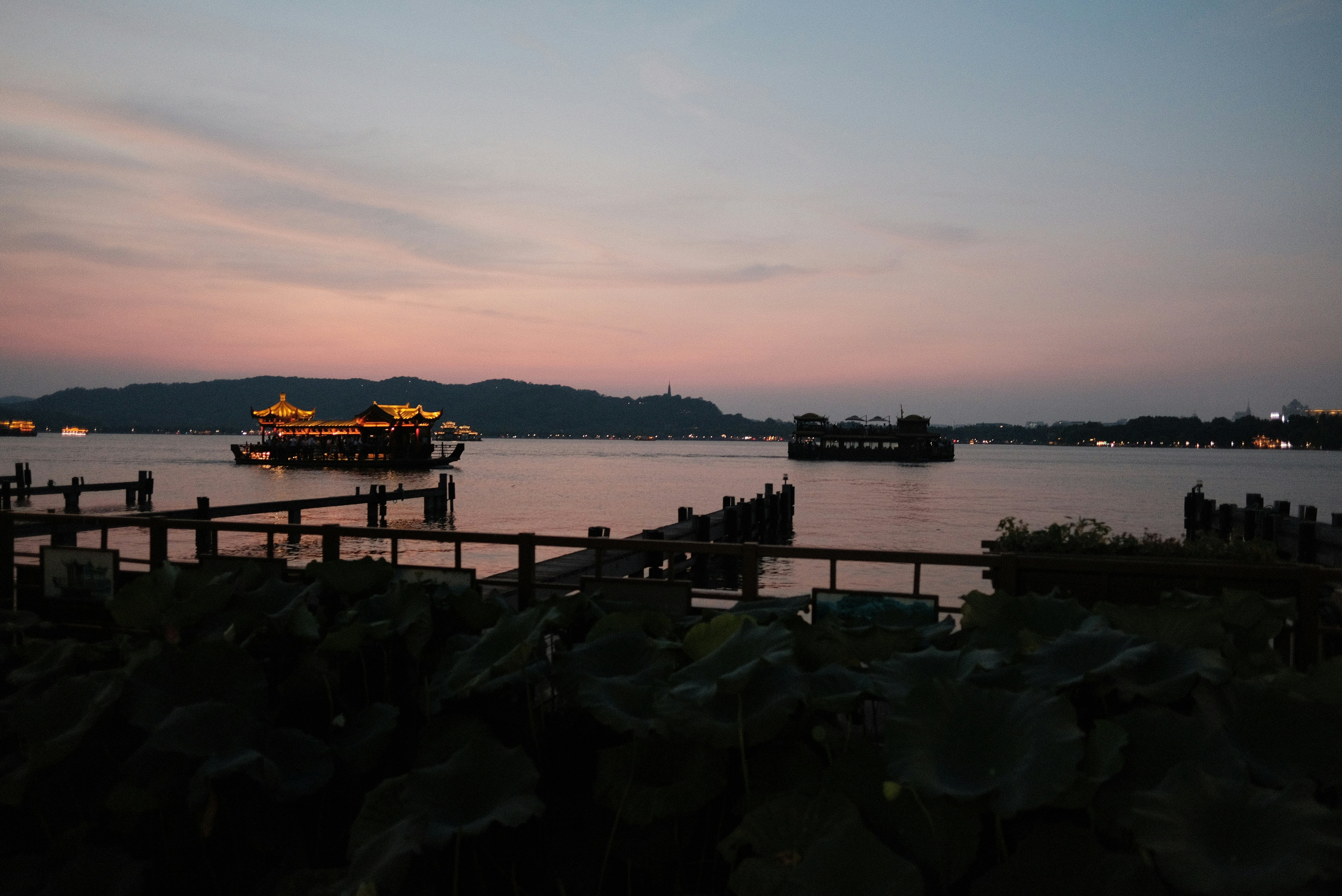 Dusk Lanterns Over a Tranquil Harbor: Boats, Pavilions, and Calm Water
