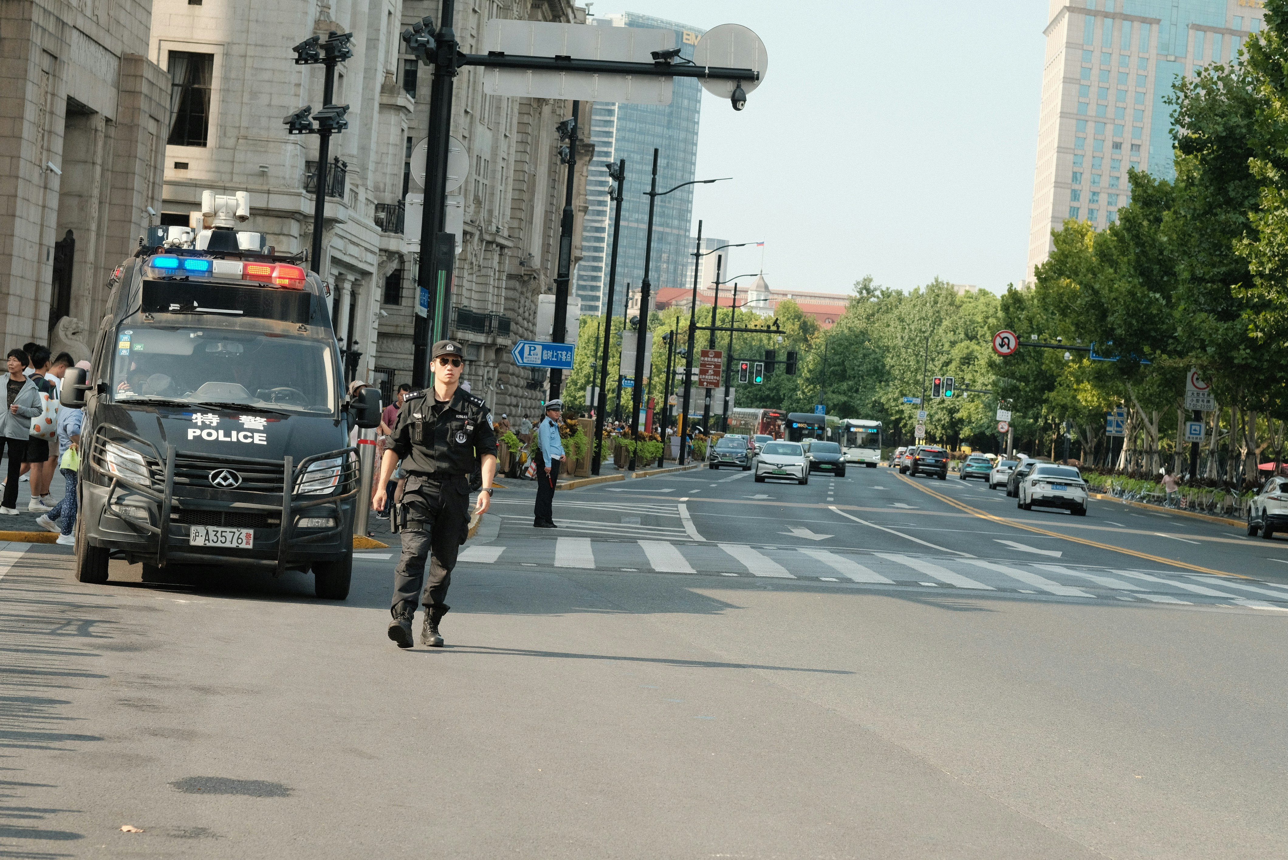 A police officer walking across a street next to a police car photo ...