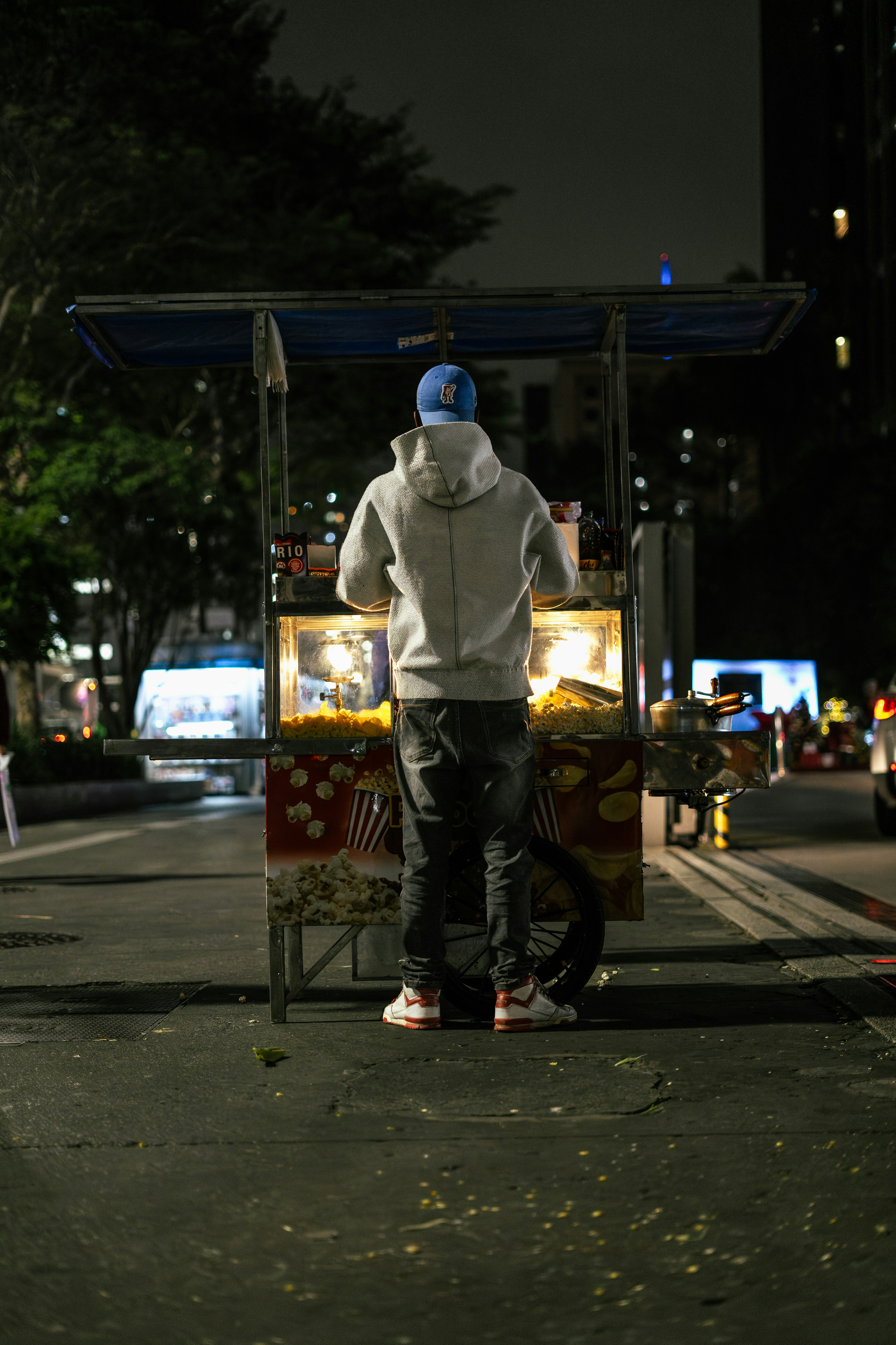 A man standing next to a vending machine on a city street