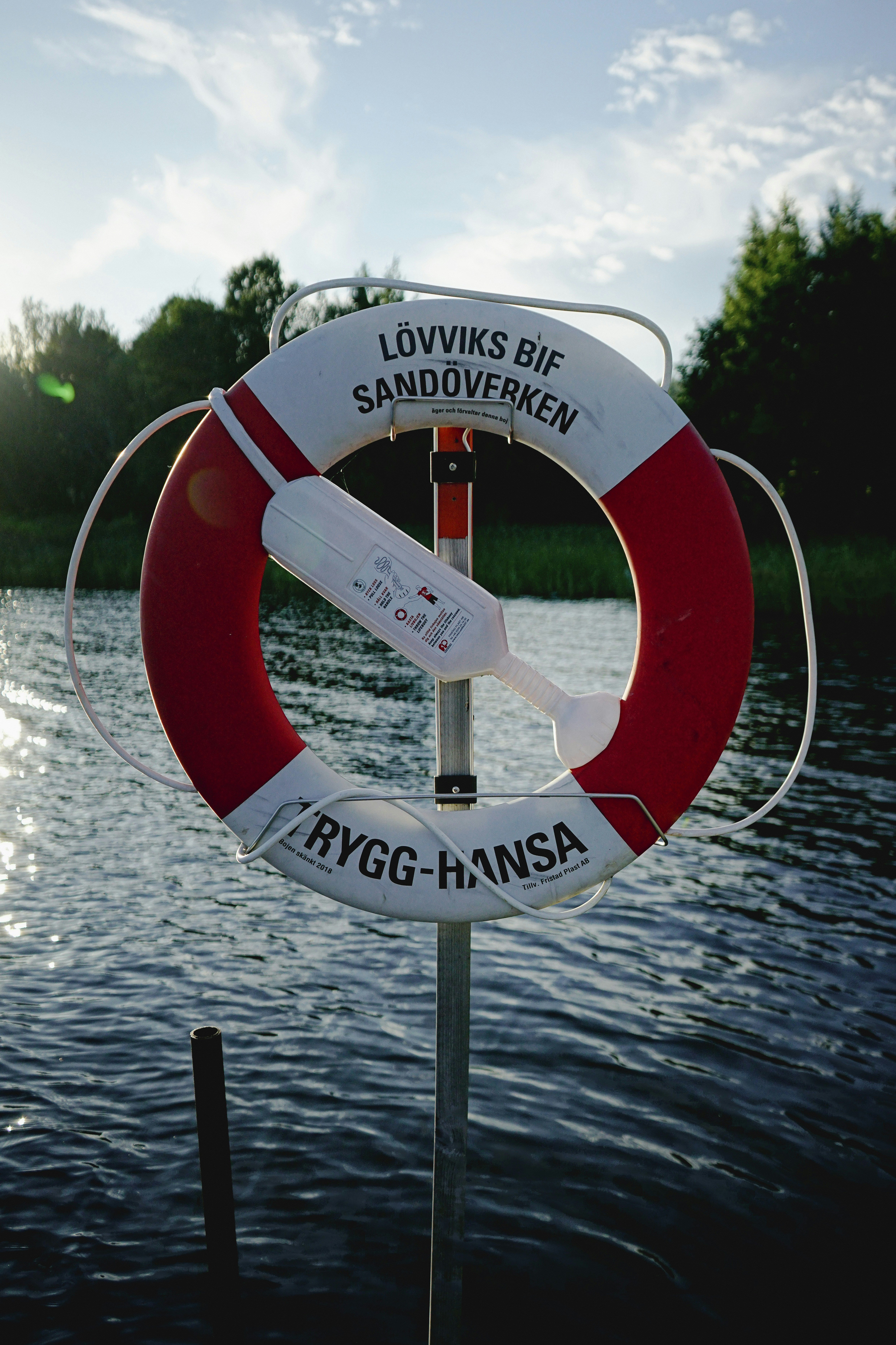 A red and white life preserver sitting on top of a body of water photo ...
