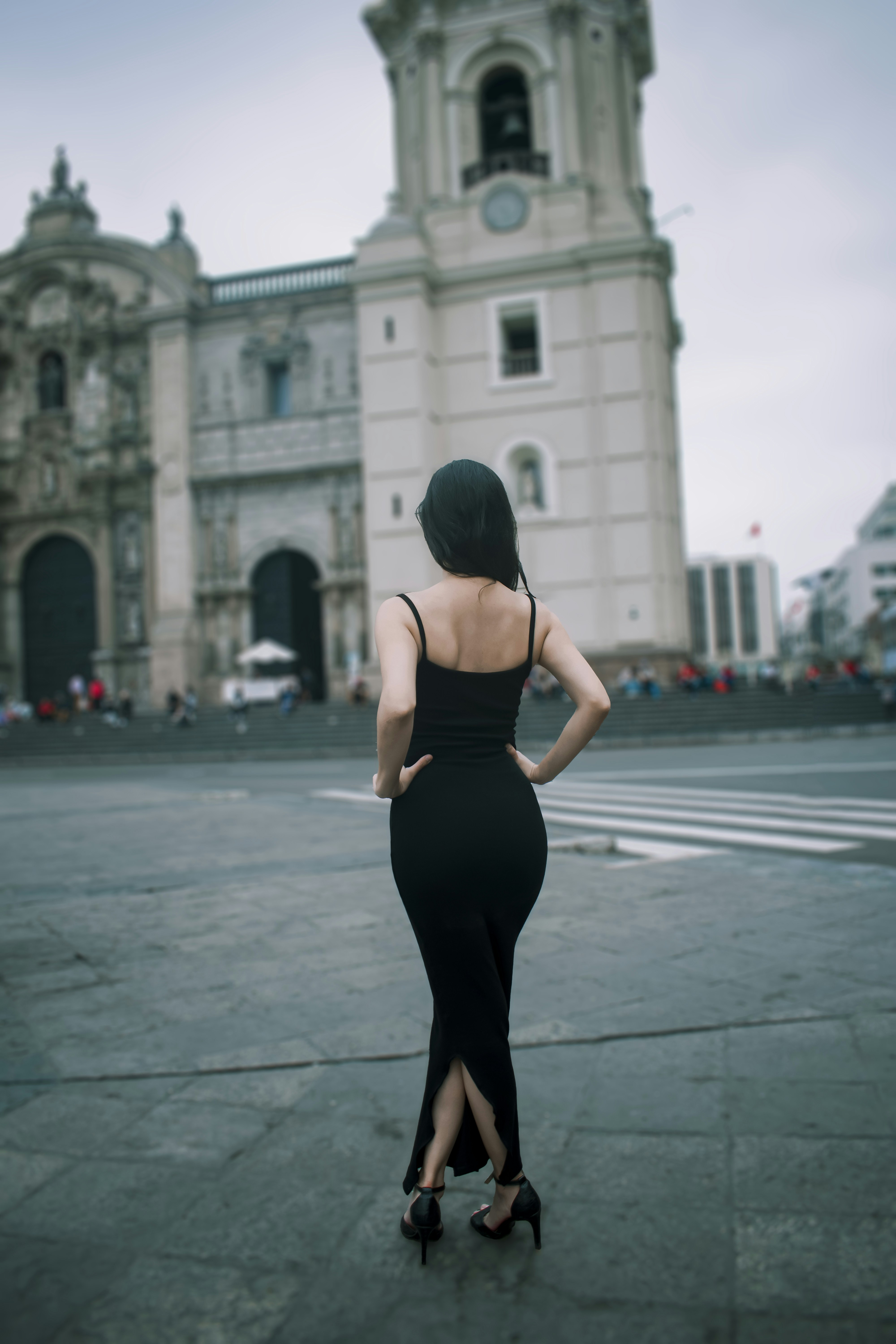 A woman in a black dress standing in front of a building photo – Free ...