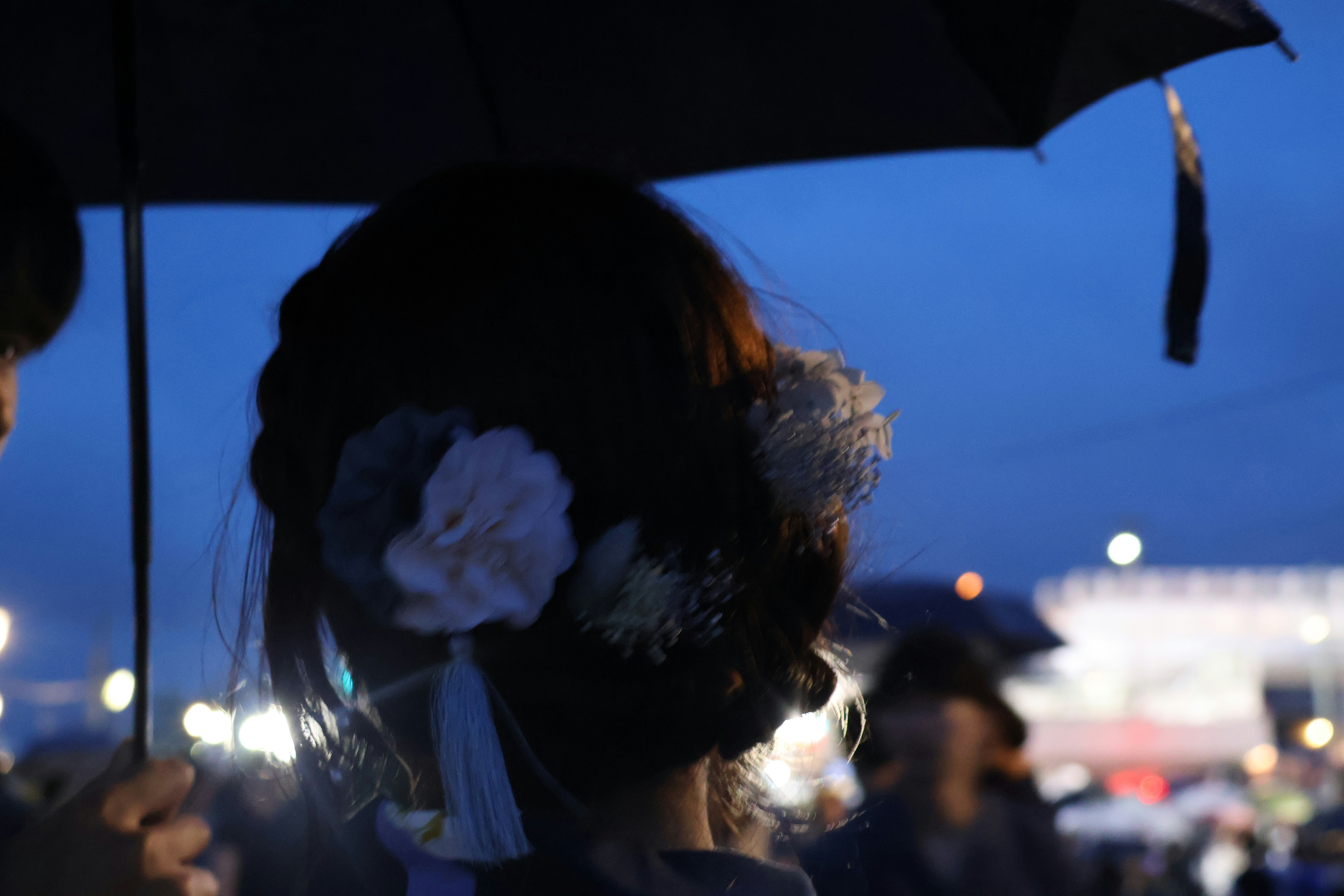 girl with fully decorated hair waiting for hanabi to rise during a local festival