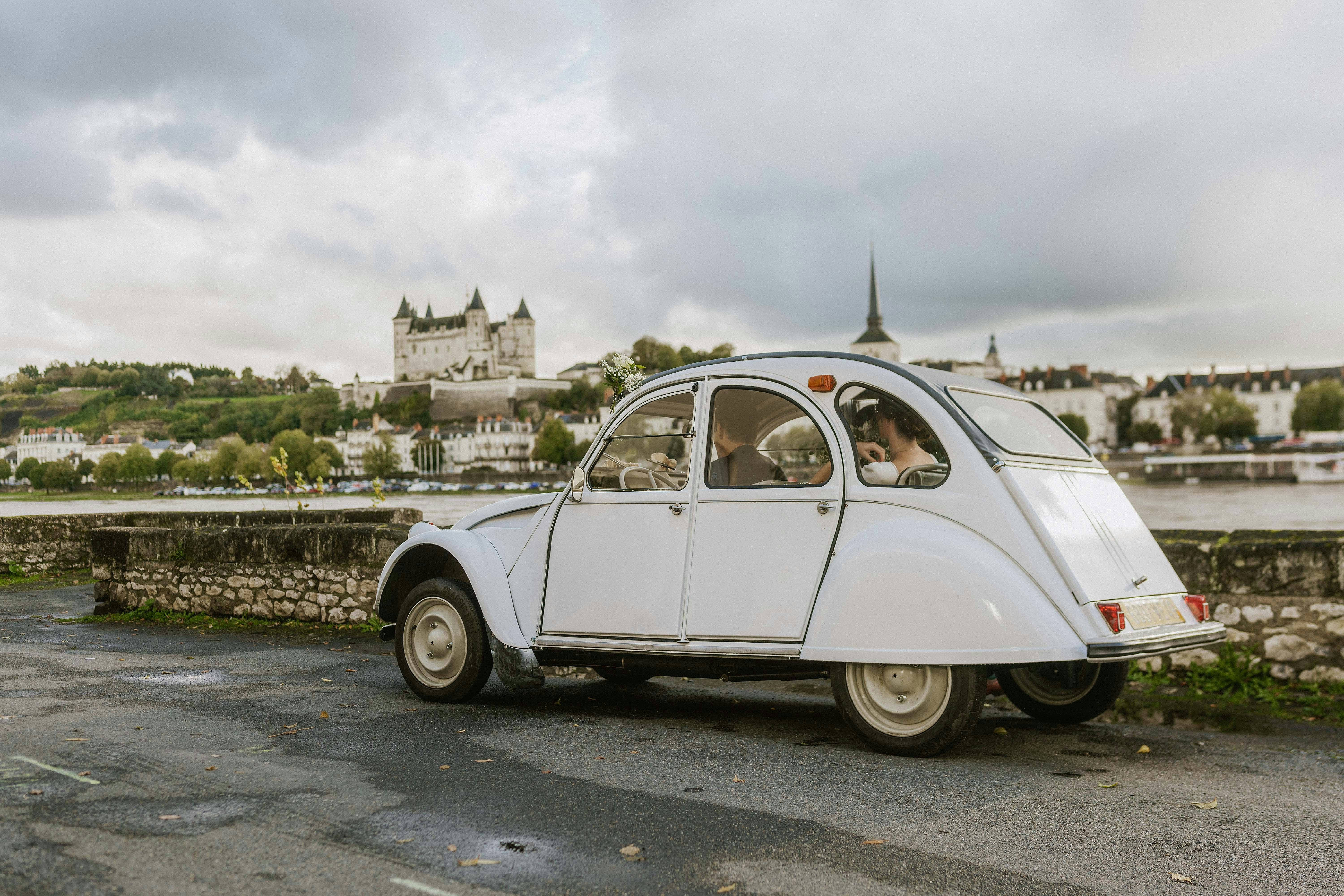 Una piccola auto bianca parcheggiata sul ciglio di una strada foto ...