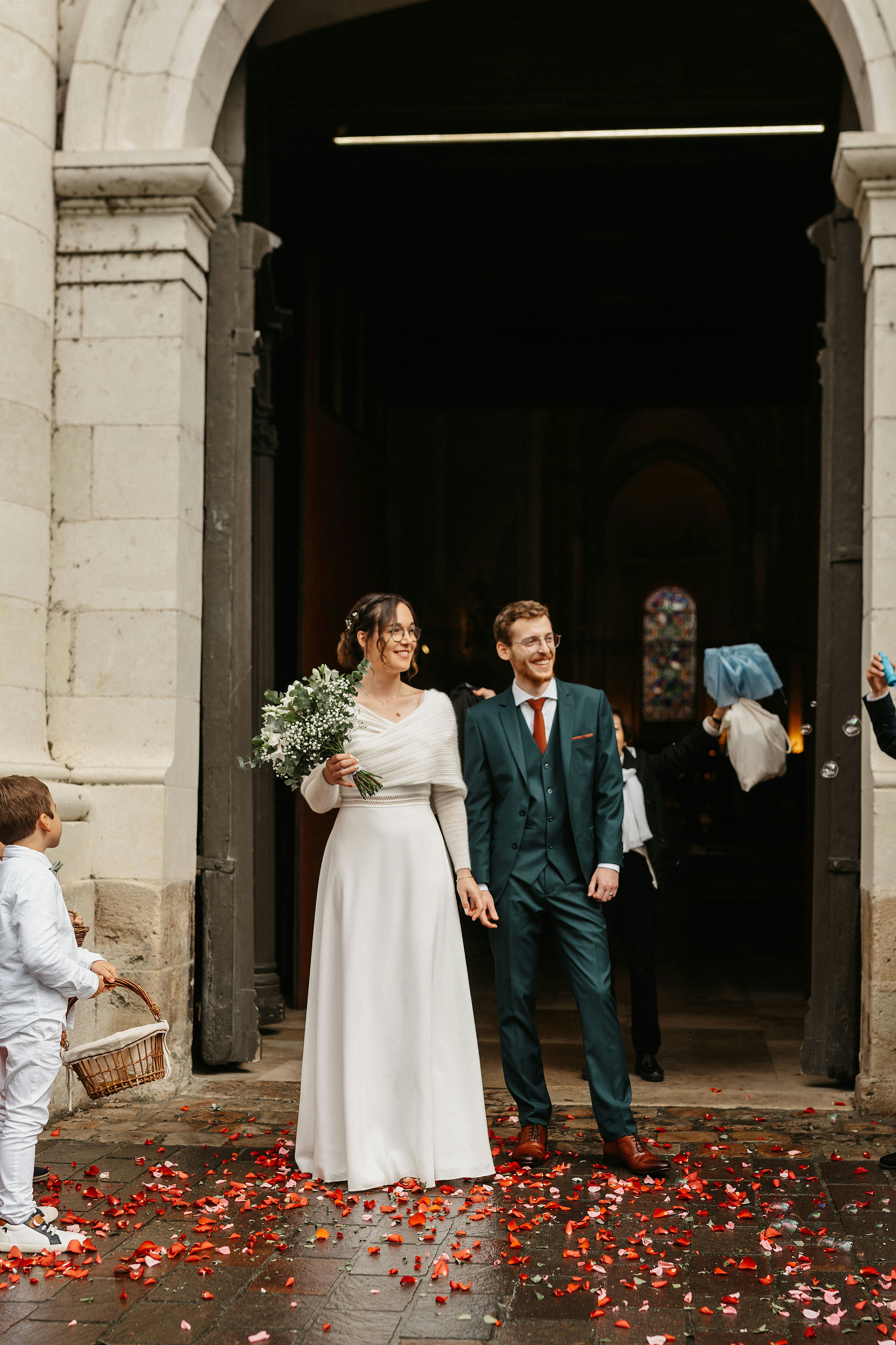 Petals at the Portal: A Bride and Groom Exit under Stone Arches