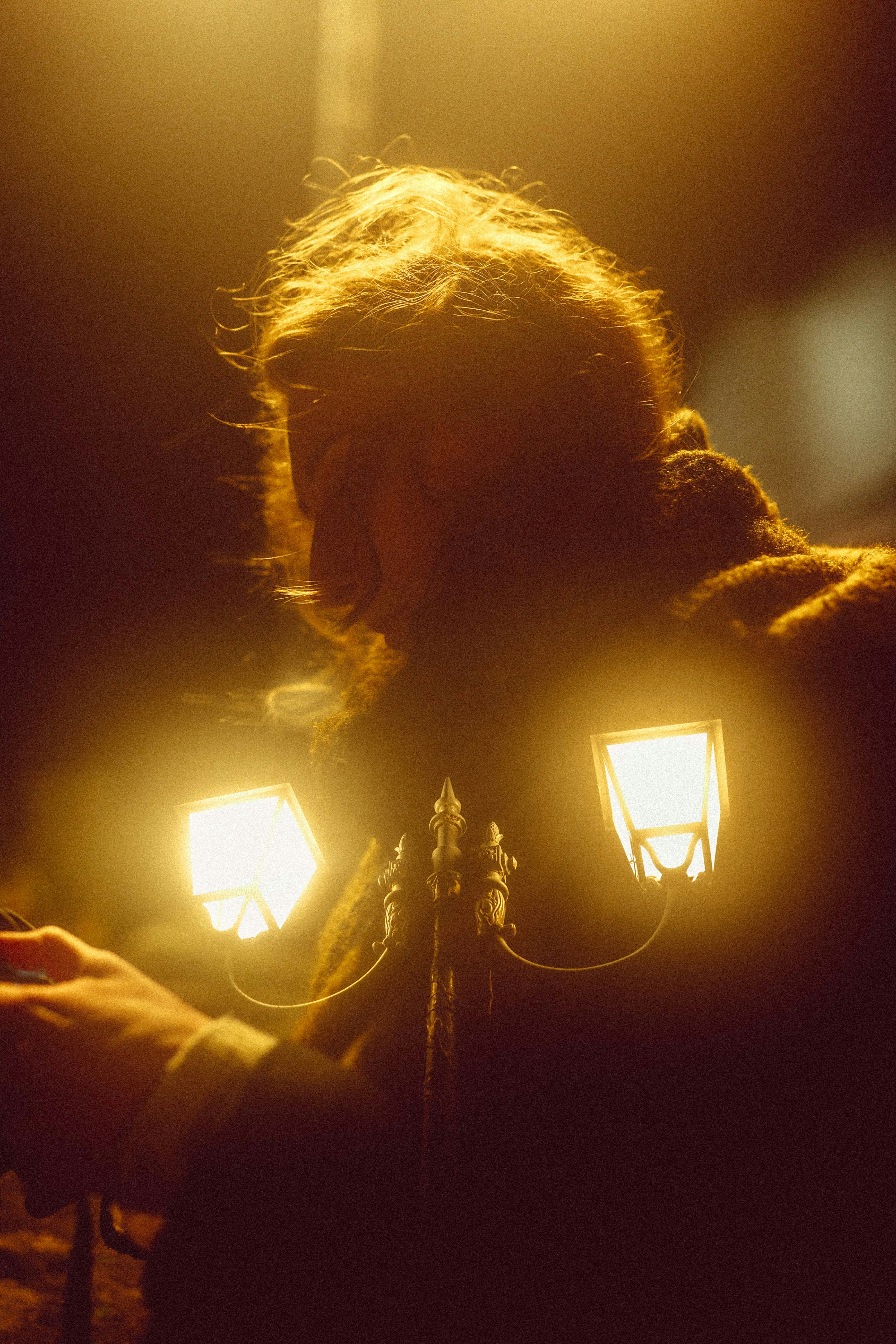 Amber Halo: Night Portrait Between Twin Lanterns