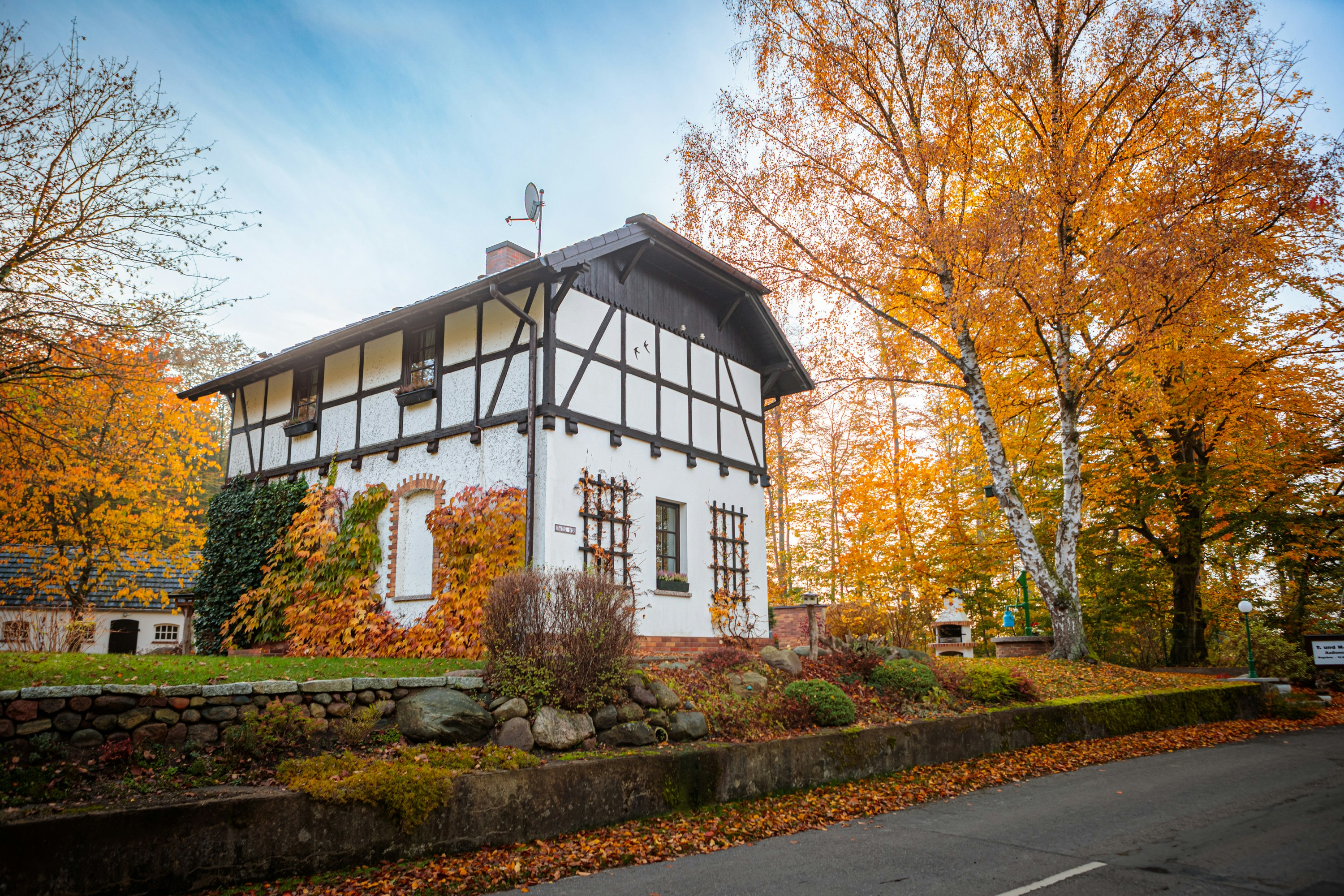 Autumnal Timber-Framed Cottage Framed by Crimson and Gold Foliage