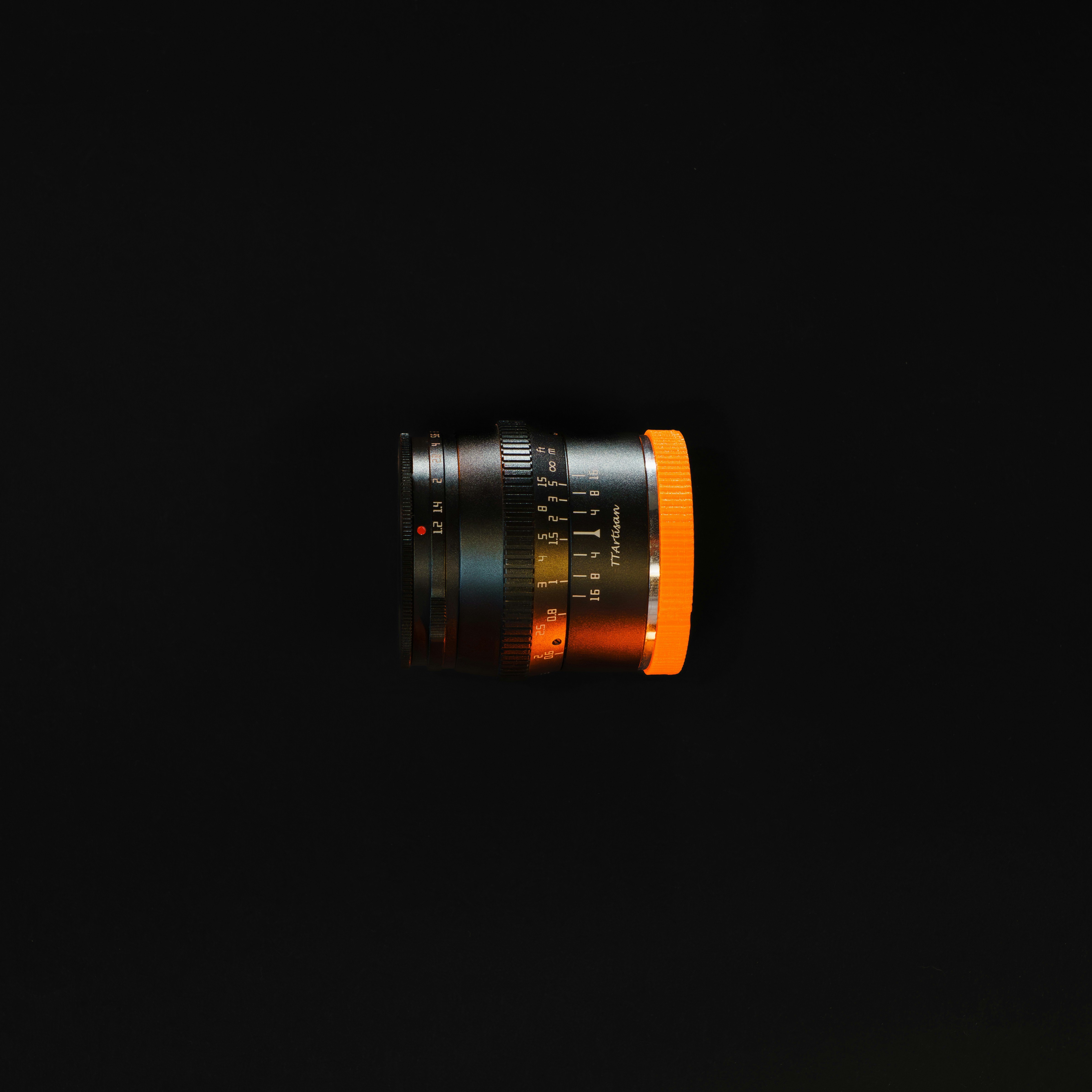 An orange camera lens on a black background photo – Free Photography ...
