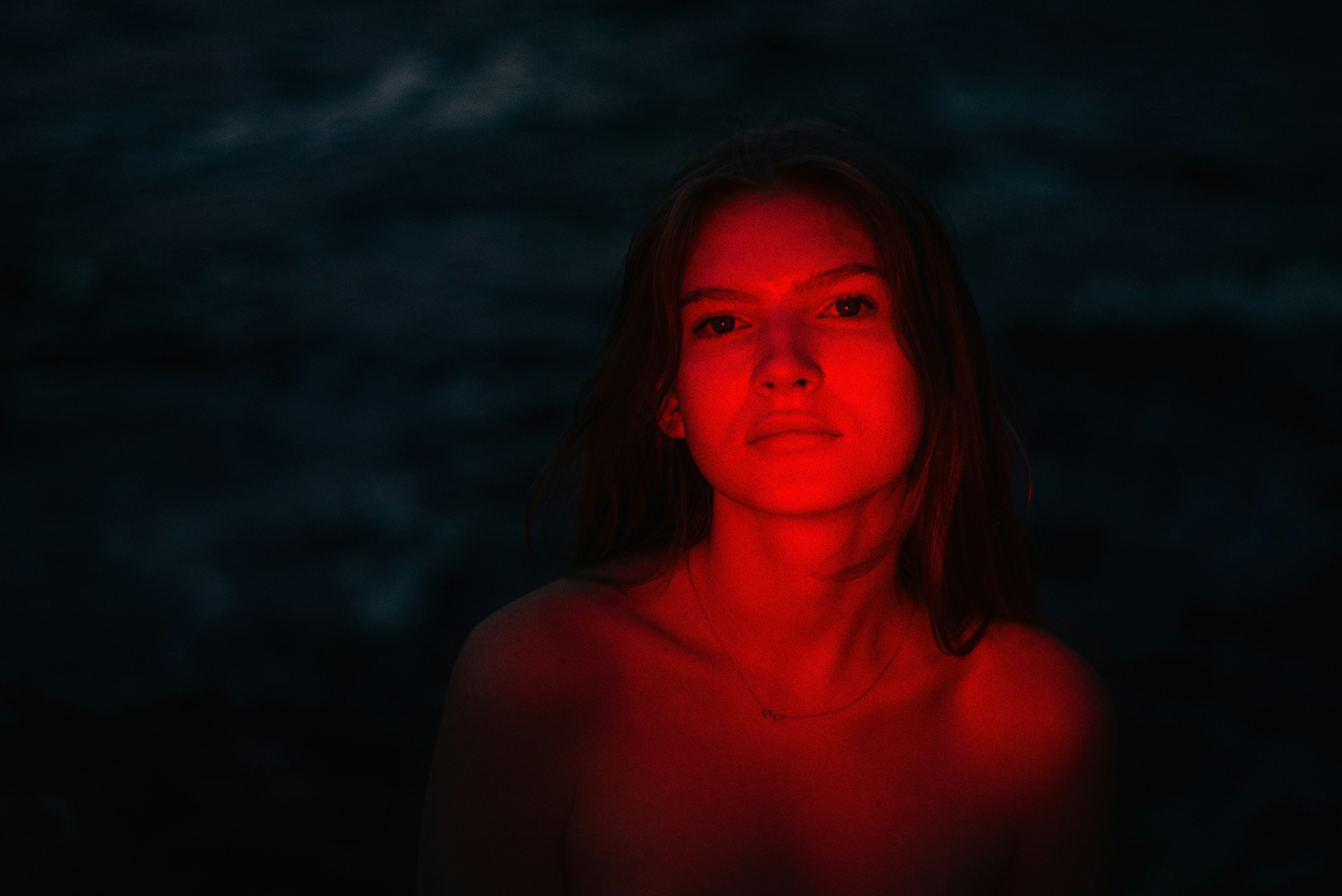 A woman standing in the dark with a red light photo – Free Portrait ...