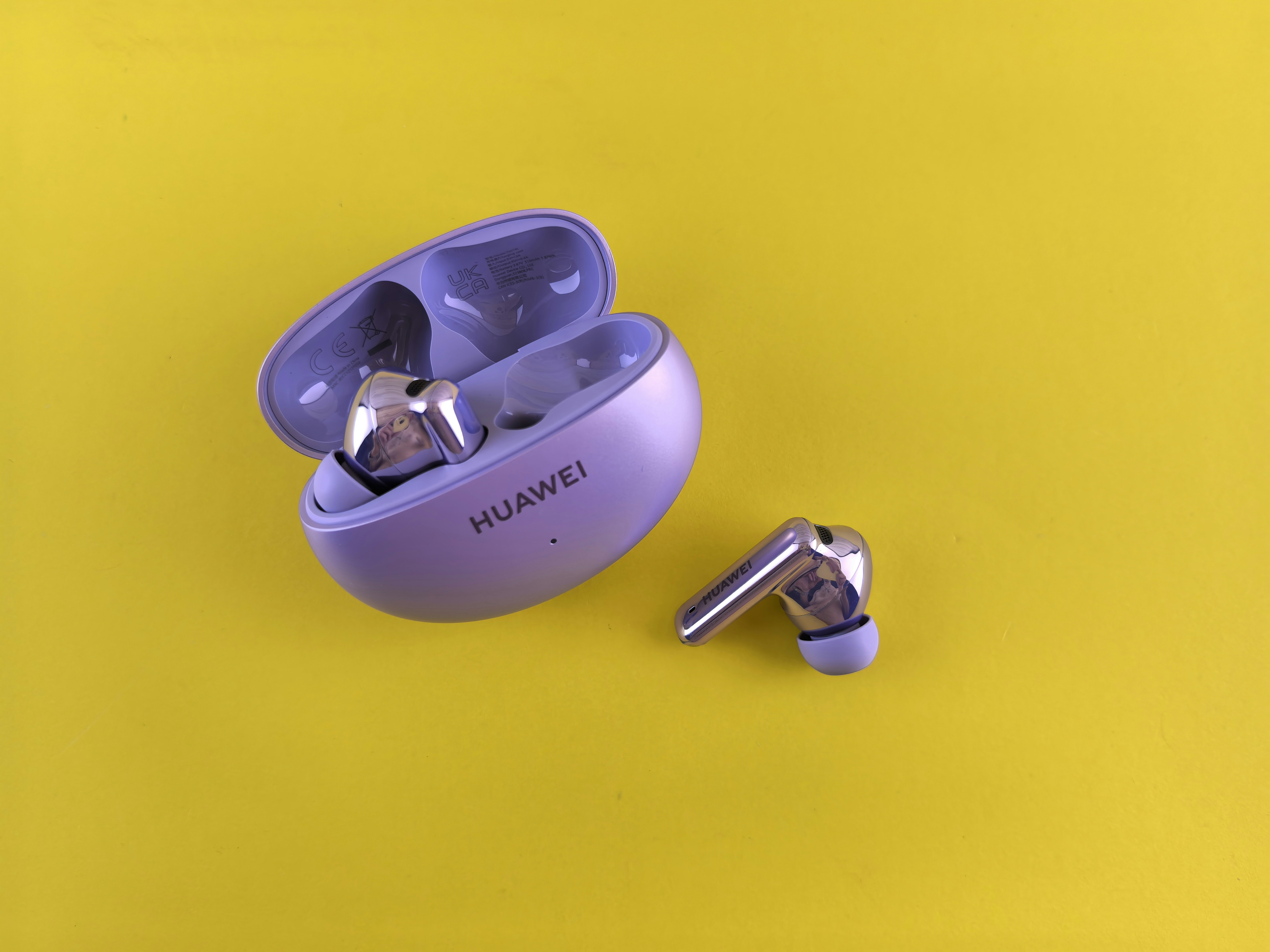 A pair of ear buds sitting on top of a yellow surface photo – Free ...